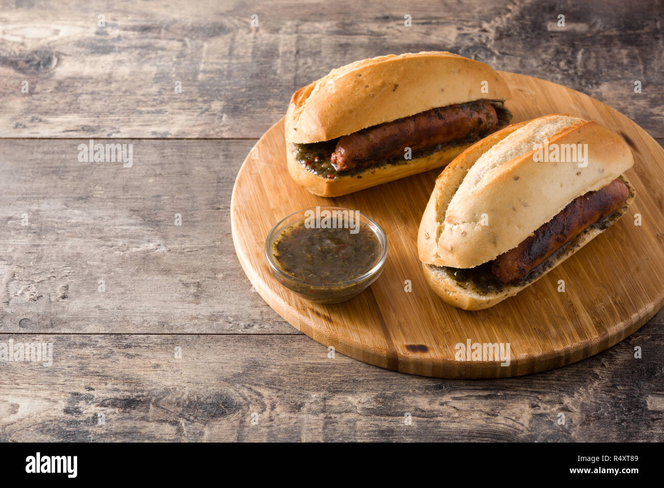 Choripan. Traditional Argentina sandwich with chorizo and chimichurri ...