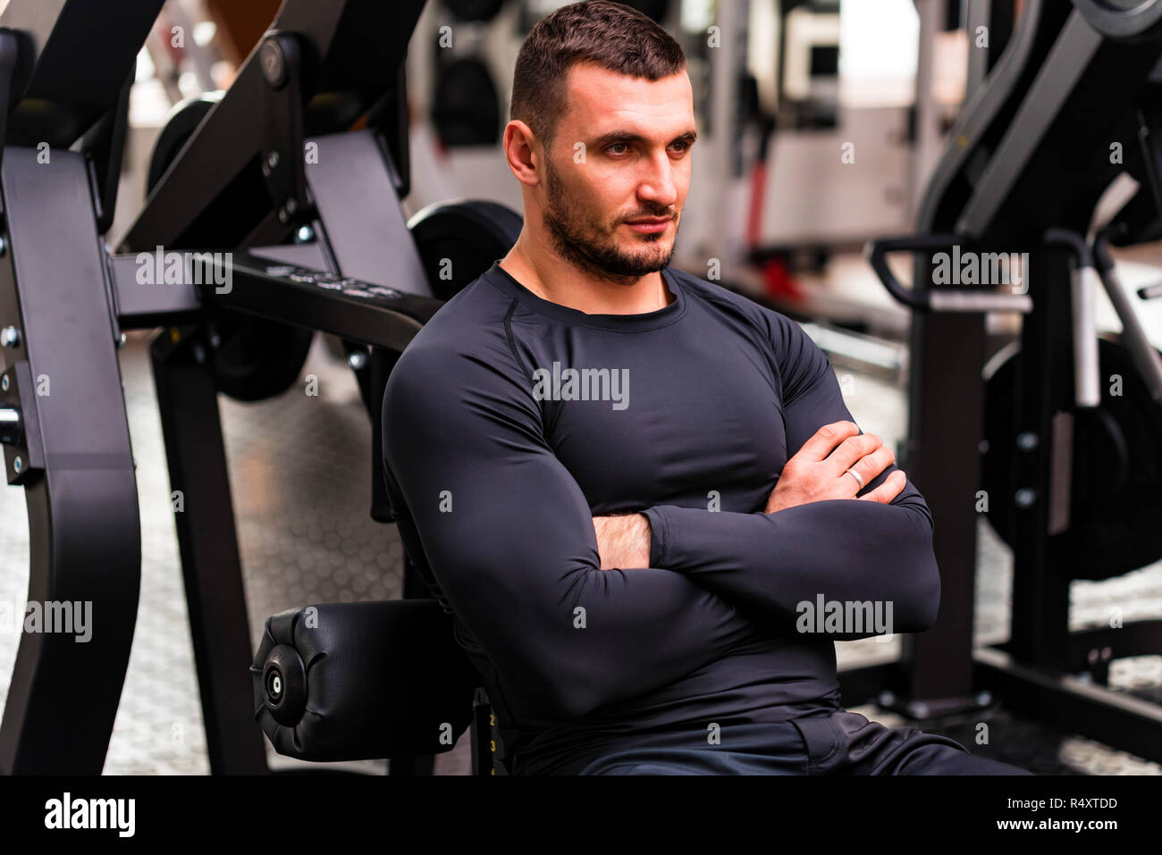 Young handsome fitness trainer sits modern gym Stock Photo - Alamy