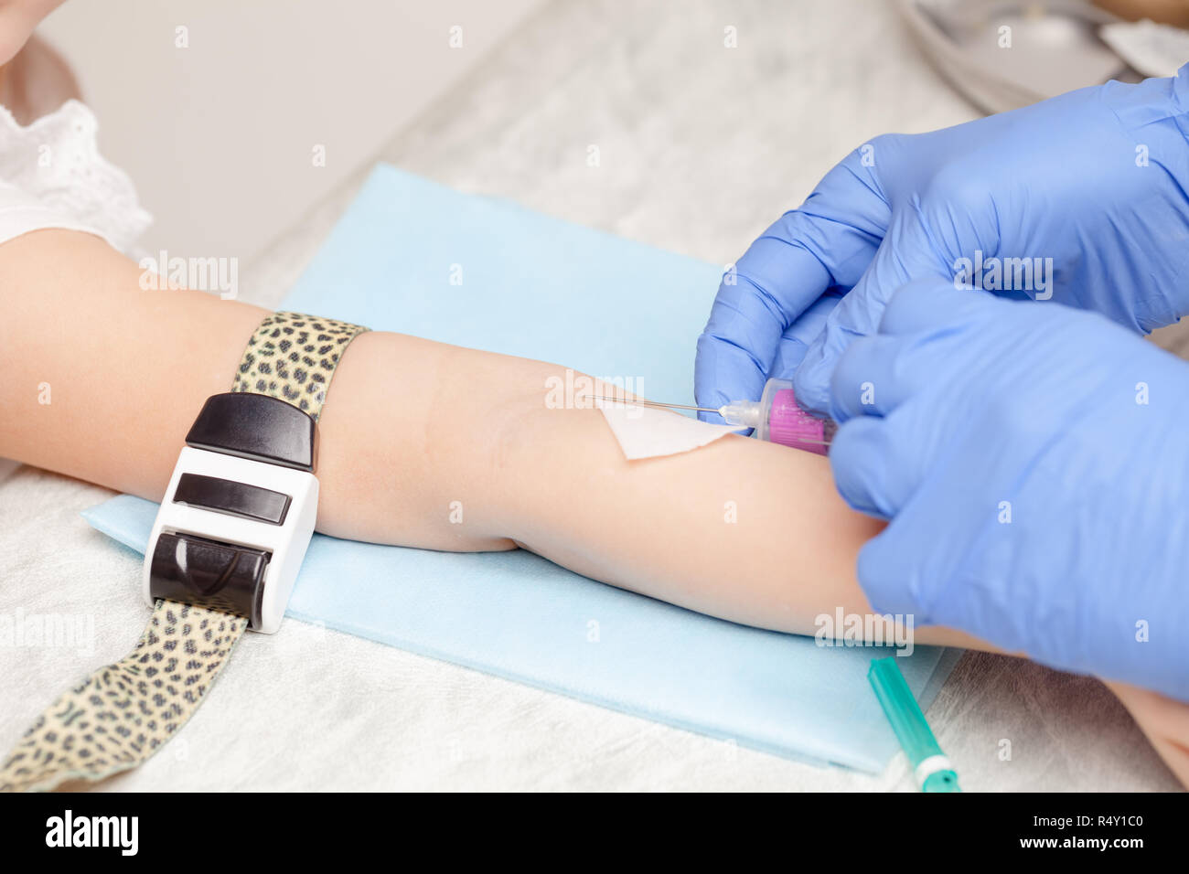 Doctor or nurse ready to take a blood sample from little girl's arm ...
