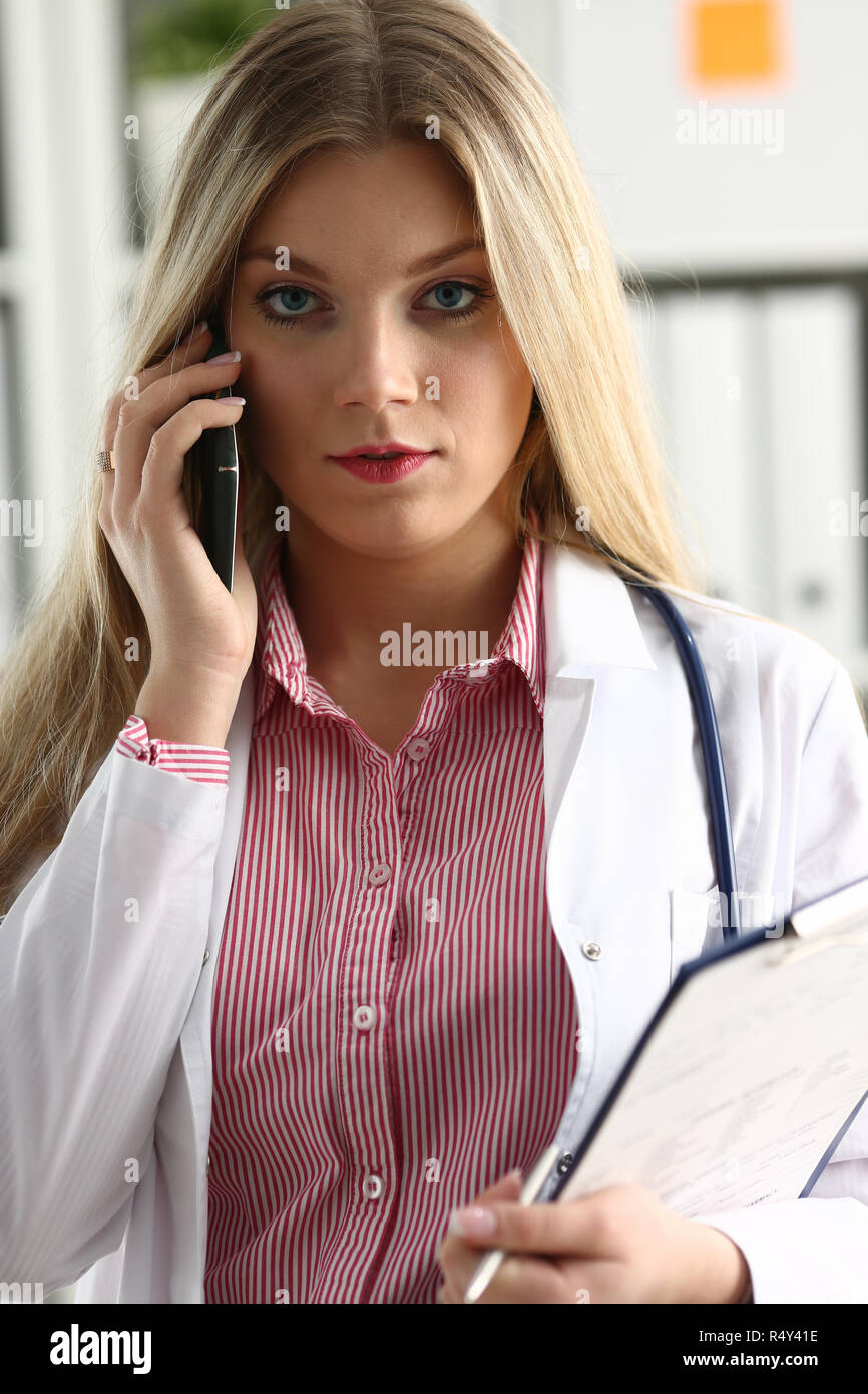 Beautiful female blond doctor talking on phone Stock Photo - Alamy