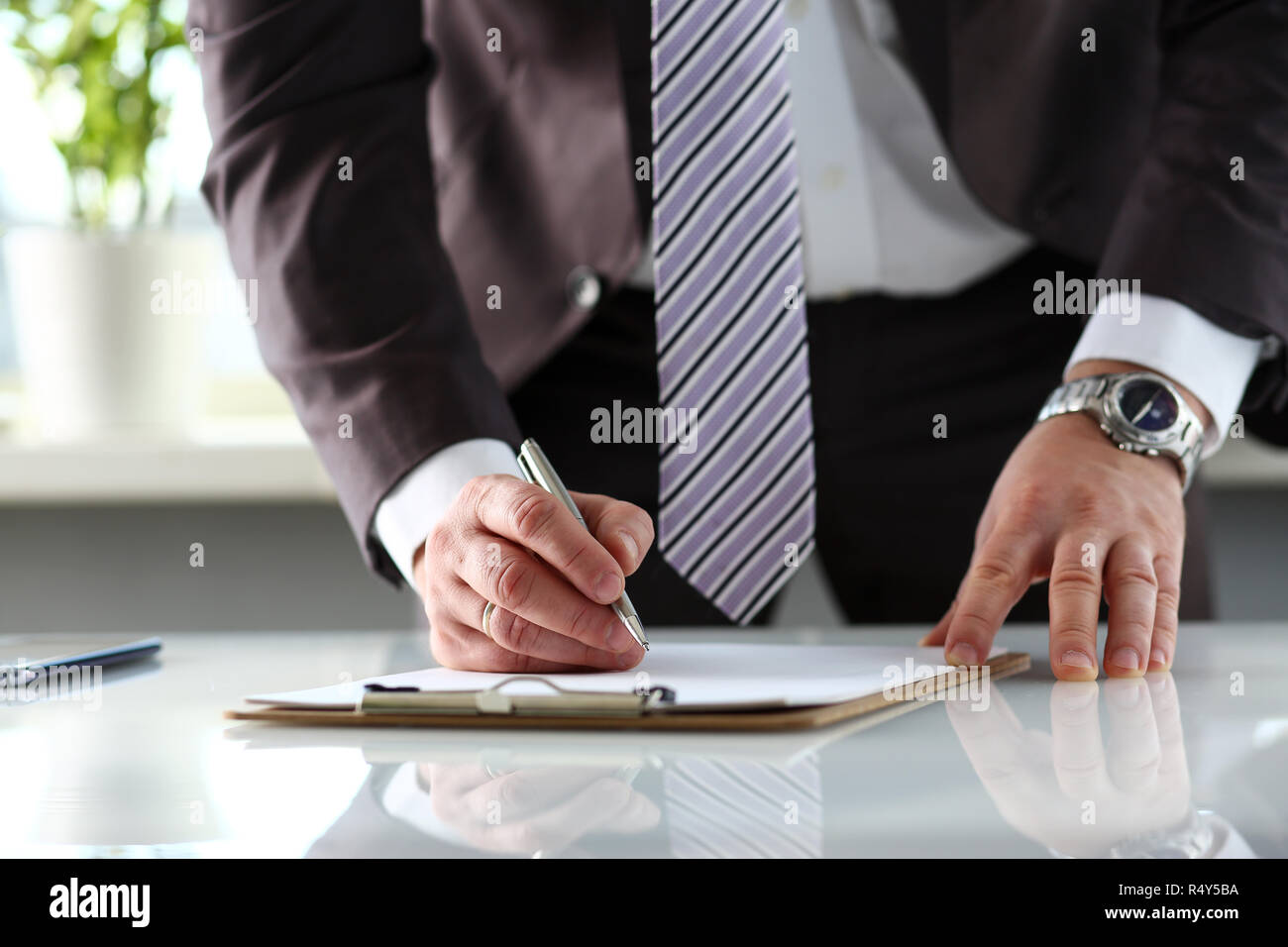 Male arm in suit and tie fill form clipped to pad Stock Photo - Alamy