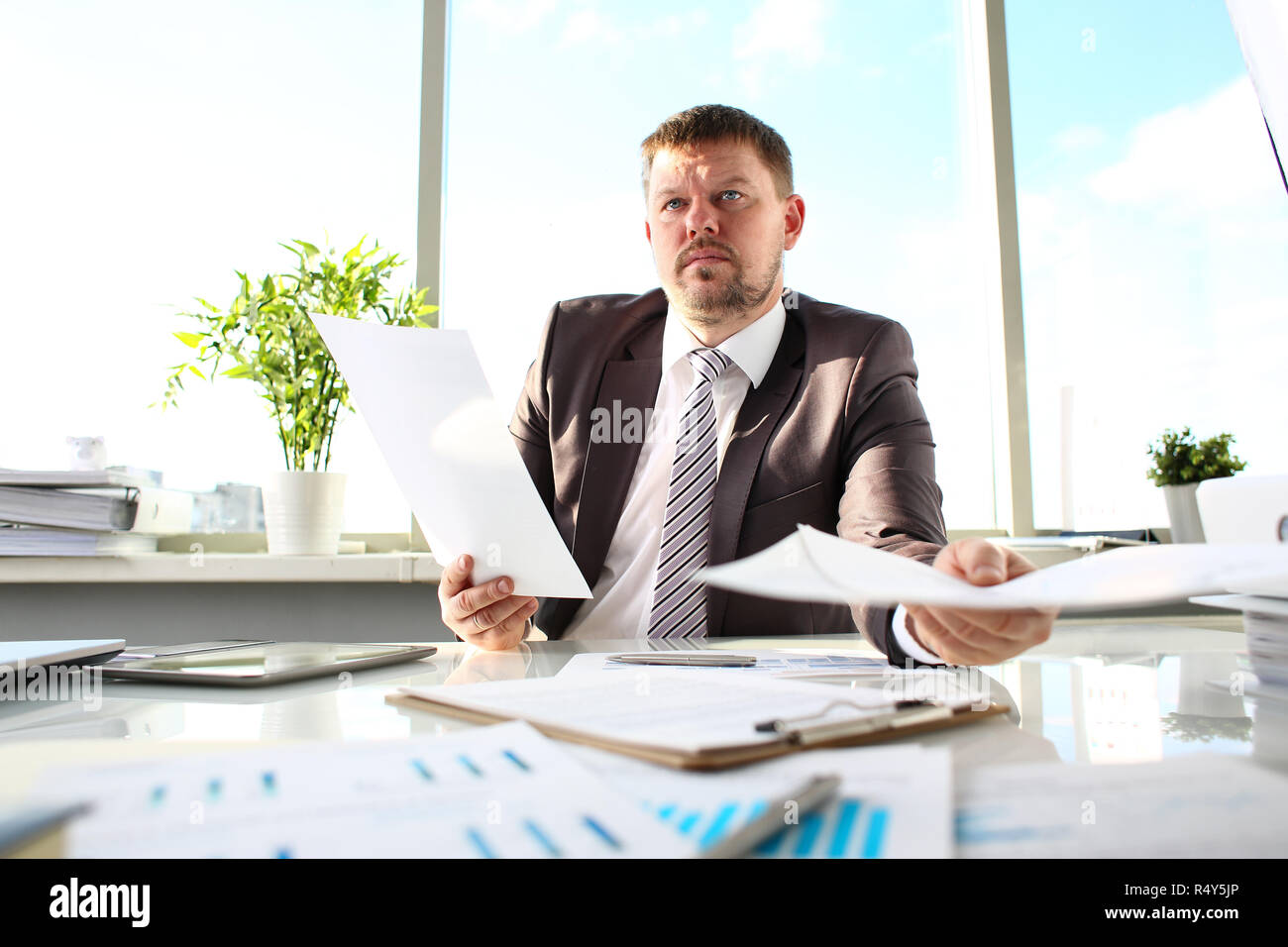 Male in suit and tie hold in arm papers at office Stock Photo - Alamy