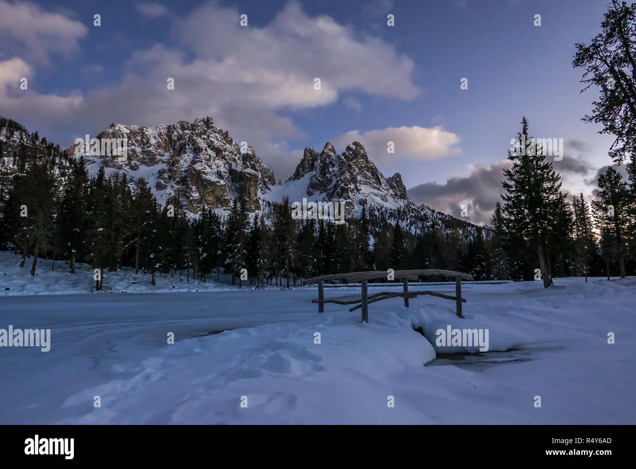 Night alpine winter scenery with small bridge on frozen lake, Cadini ...