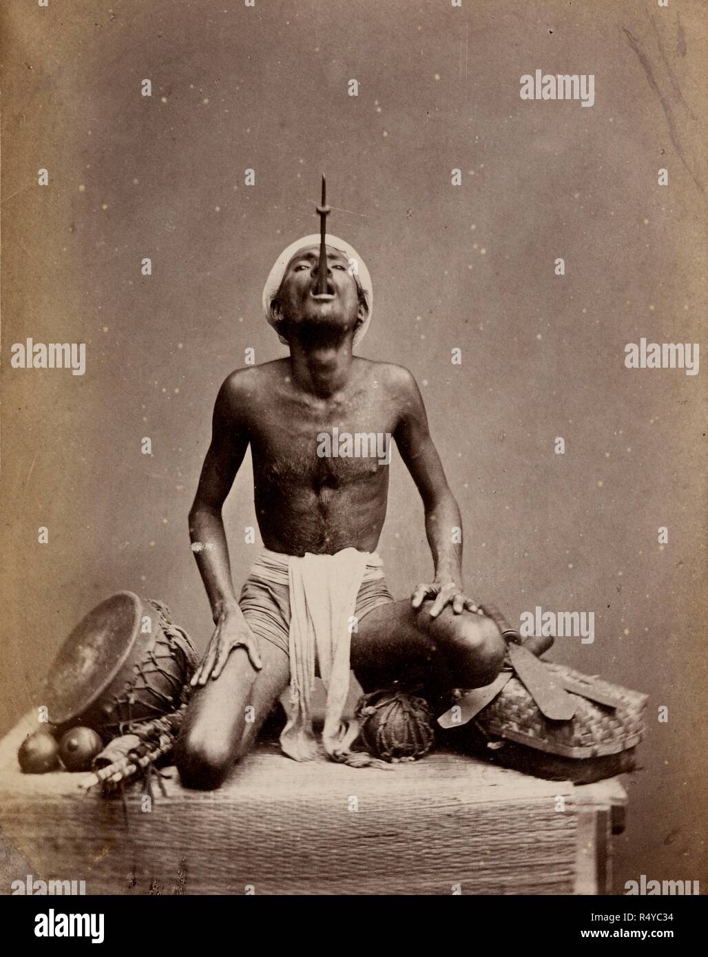 Photograph of an Indian juggler performing the sword-swallowing trick ...