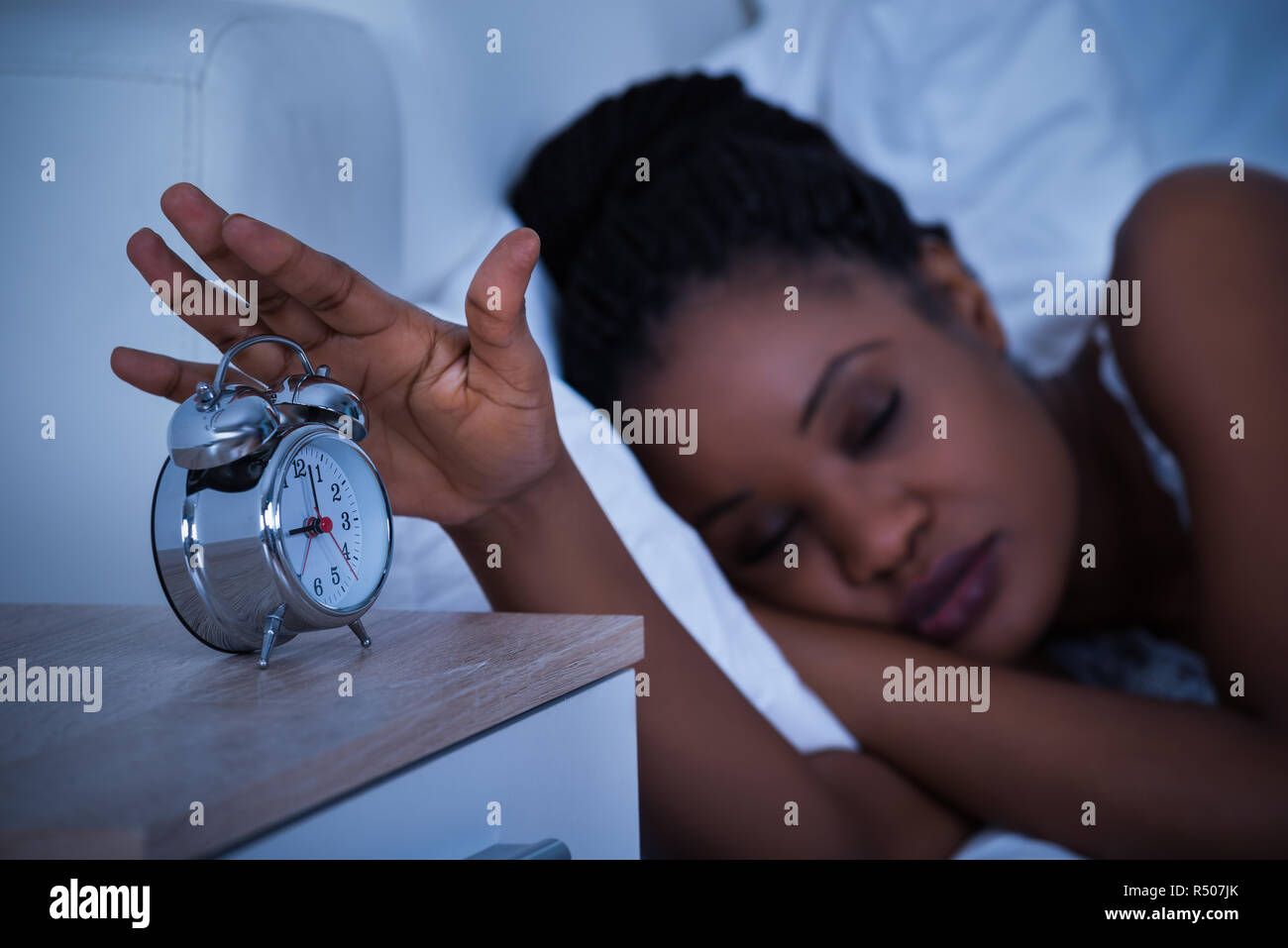 Woman Turning Off The Alarm Clock Stock Photo - Alamy