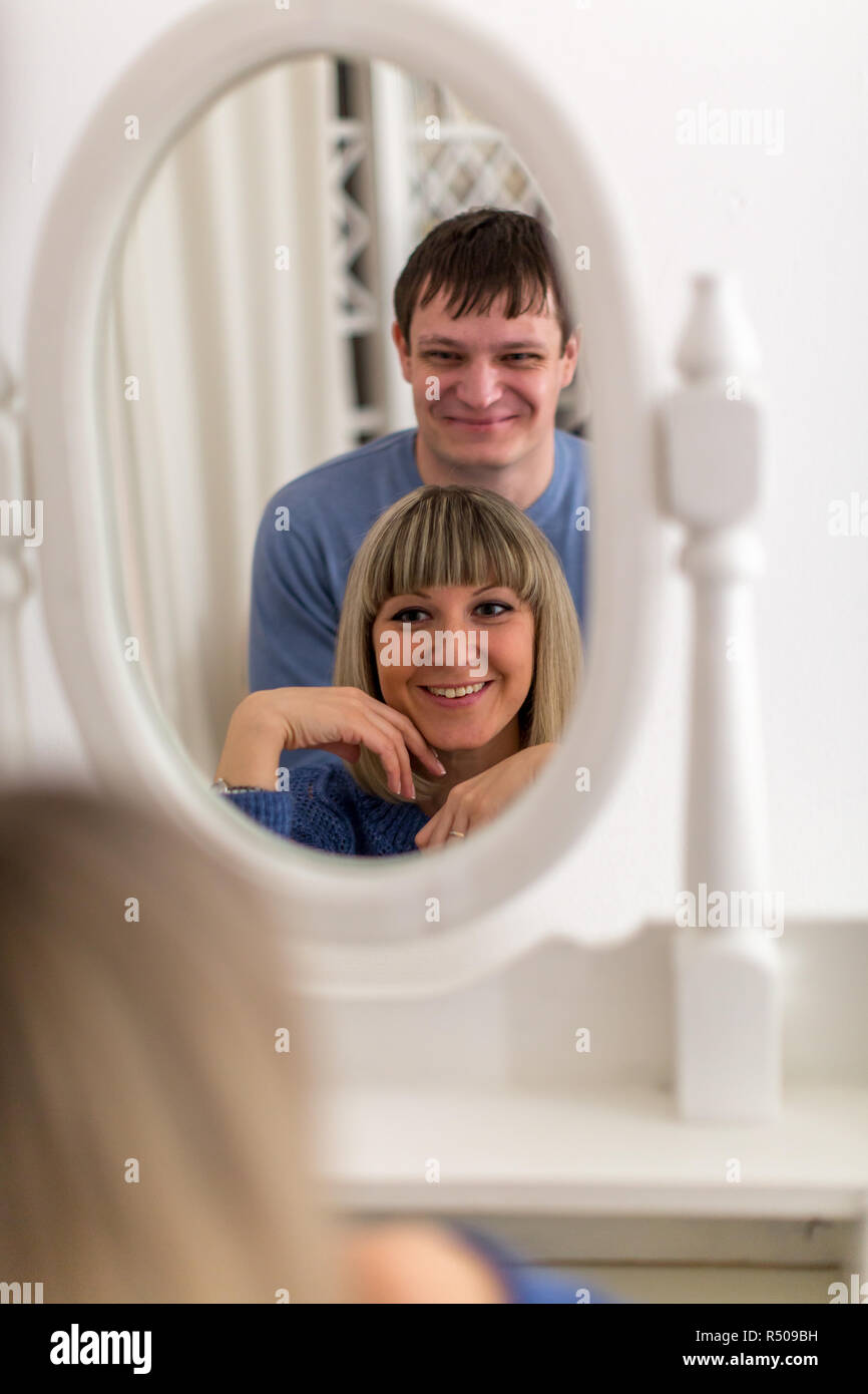 A loving couple admiring a mirror in front of a photo shoot Stock Photo ...