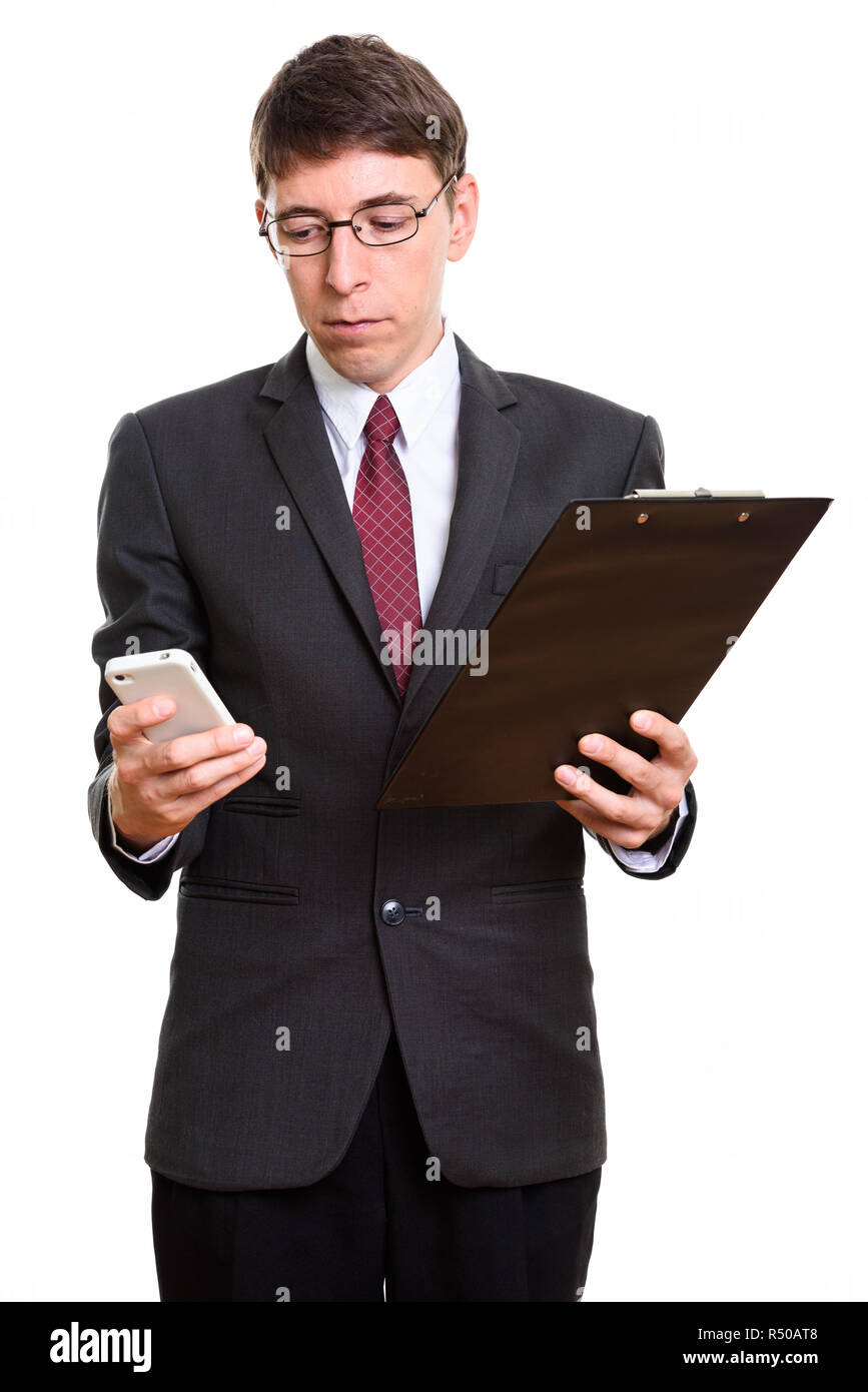 Studio shot of businessman holding clipboard while using mobile Stock ...