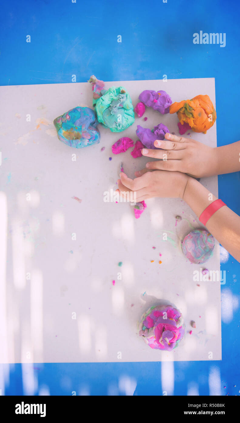 top view of kid hands Playing with Colorful Clay in outdoor Playground ...