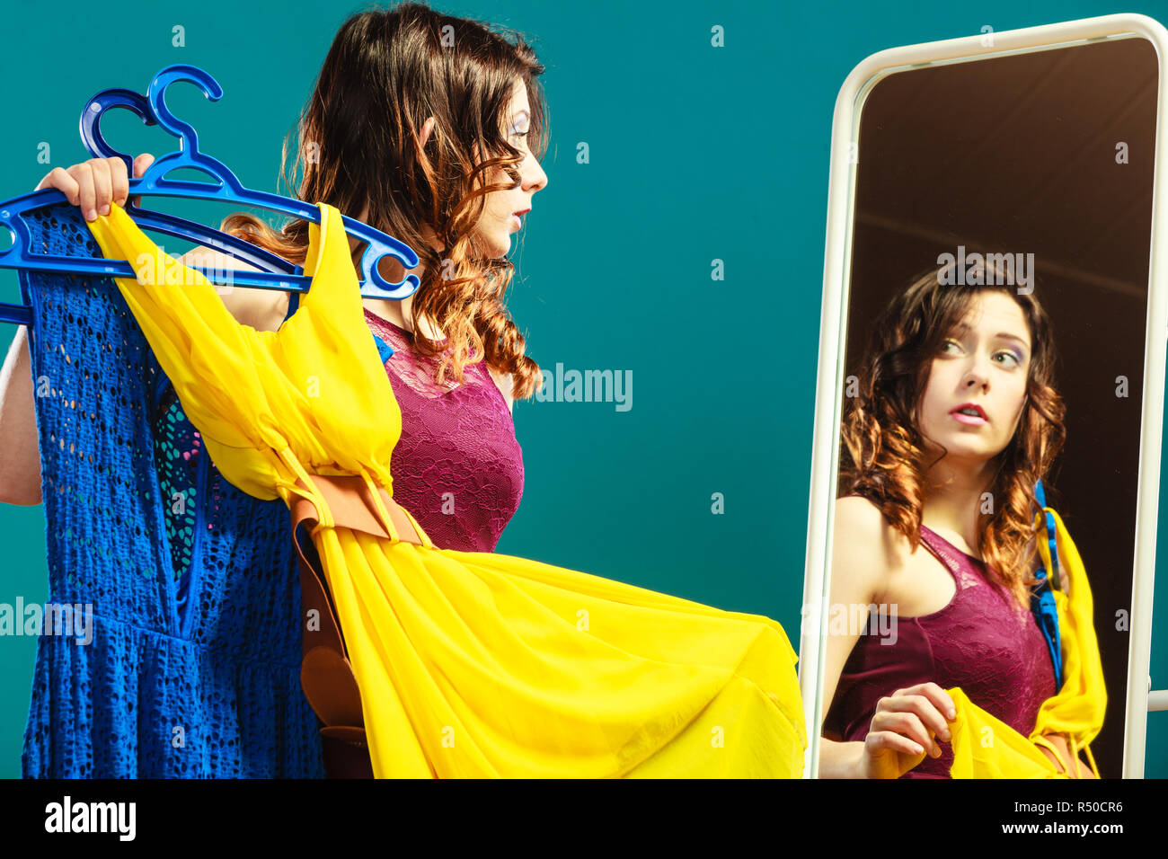 Fashion and shopping. Woman preparing to party, trying dress choosing ...