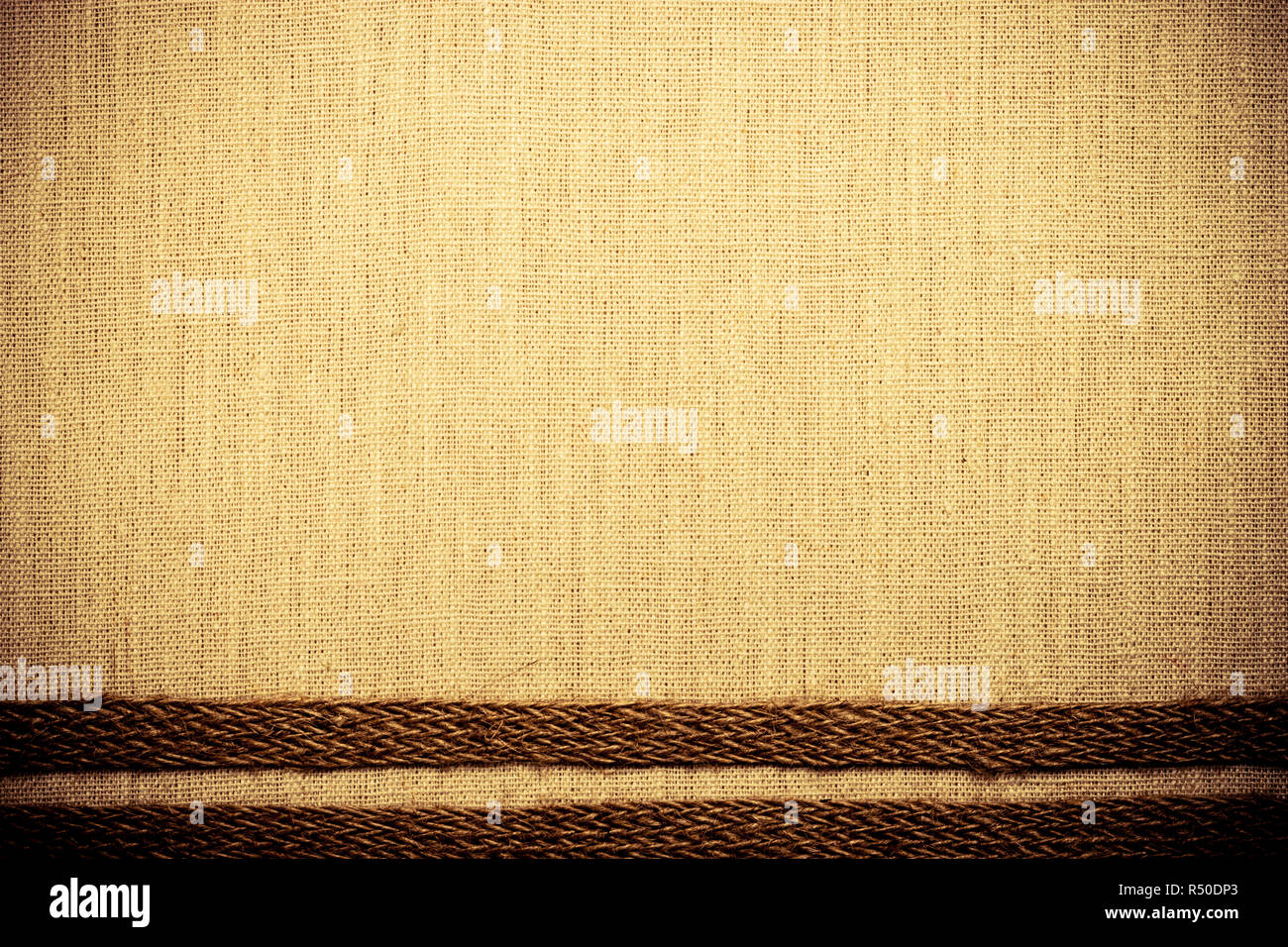 Jute bagging ribbon on bright fabric textile material, natural linen background Stock Photo - Alamy