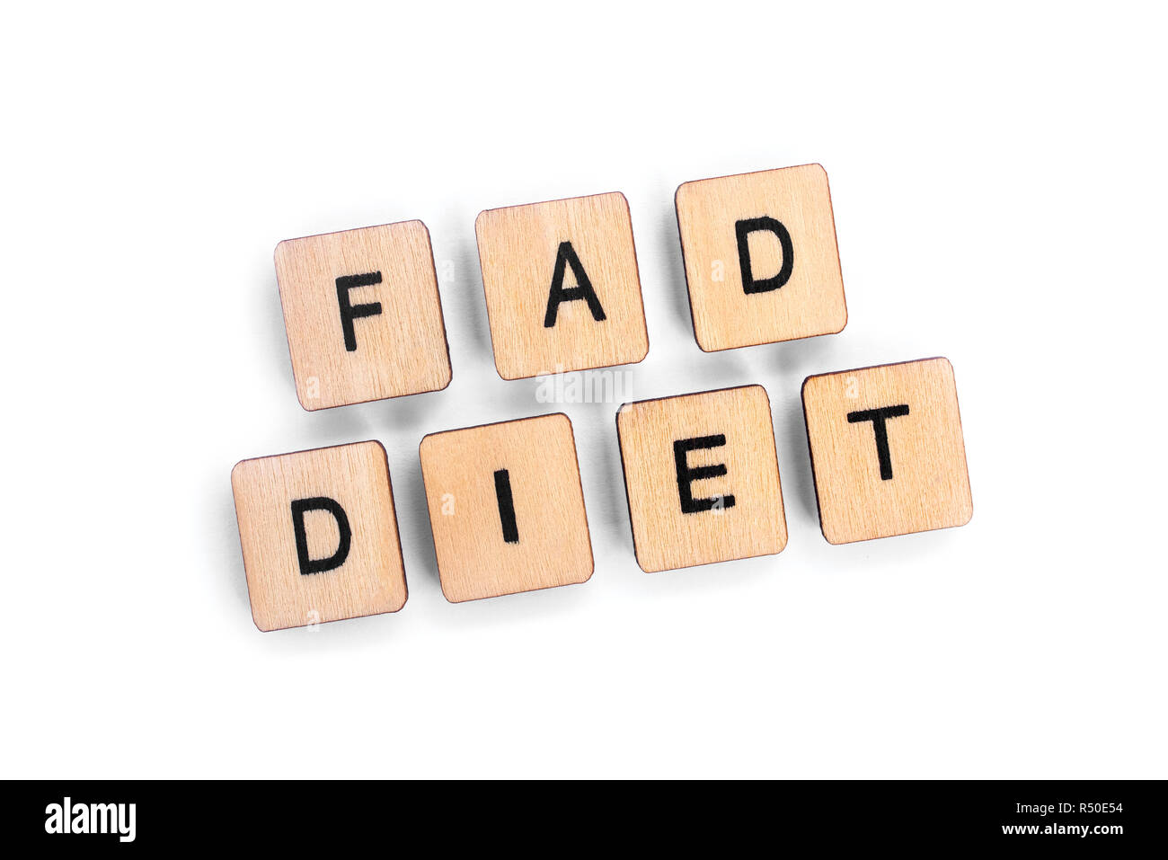 The phrase FAD DIET - spelt with wooden letter tiles over a white ...