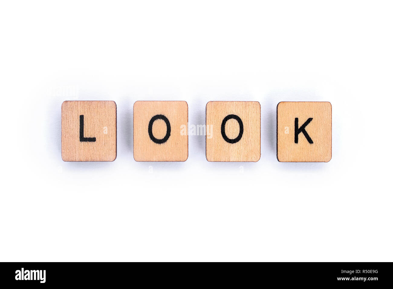 The word LOOK, spelt with wooden letter tiles over a plain white ...