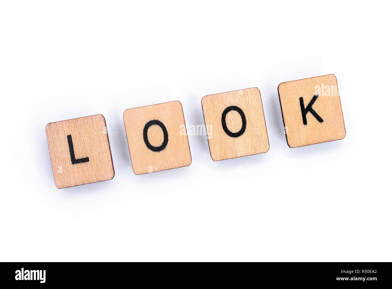 The word LOOK, spelt with wooden letter tiles over a plain white ...