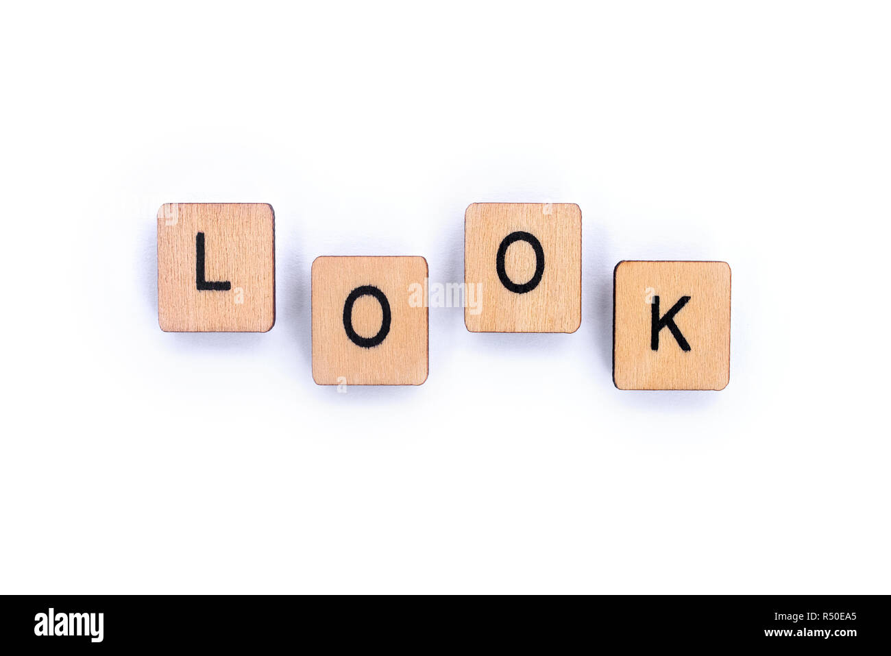 The word LOOK, spelt with wooden letter tiles over a plain white ...