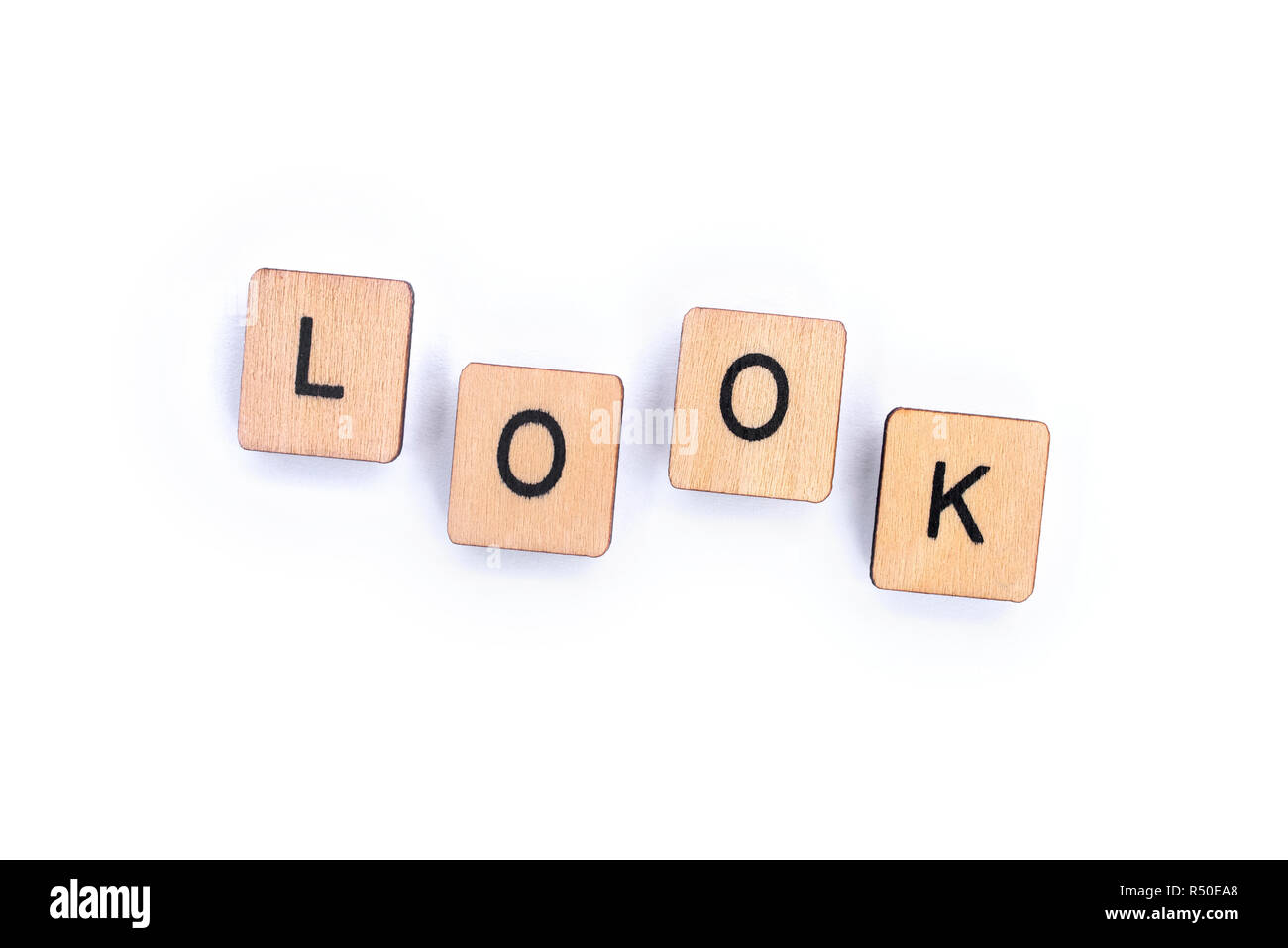 The word LOOK, spelt with wooden letter tiles over a plain white ...