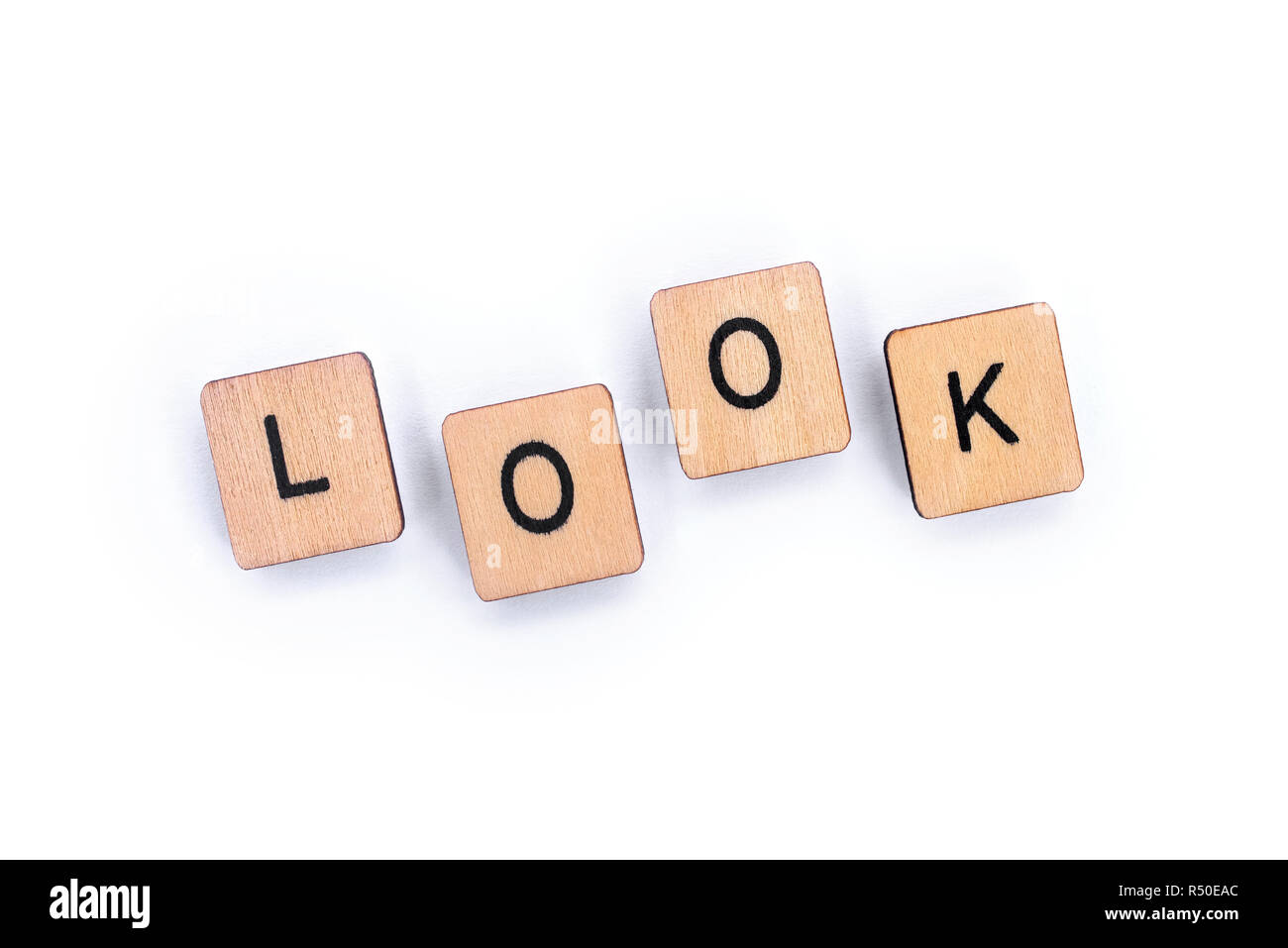 The word LOOK, spelt with wooden letter tiles over a plain white ...