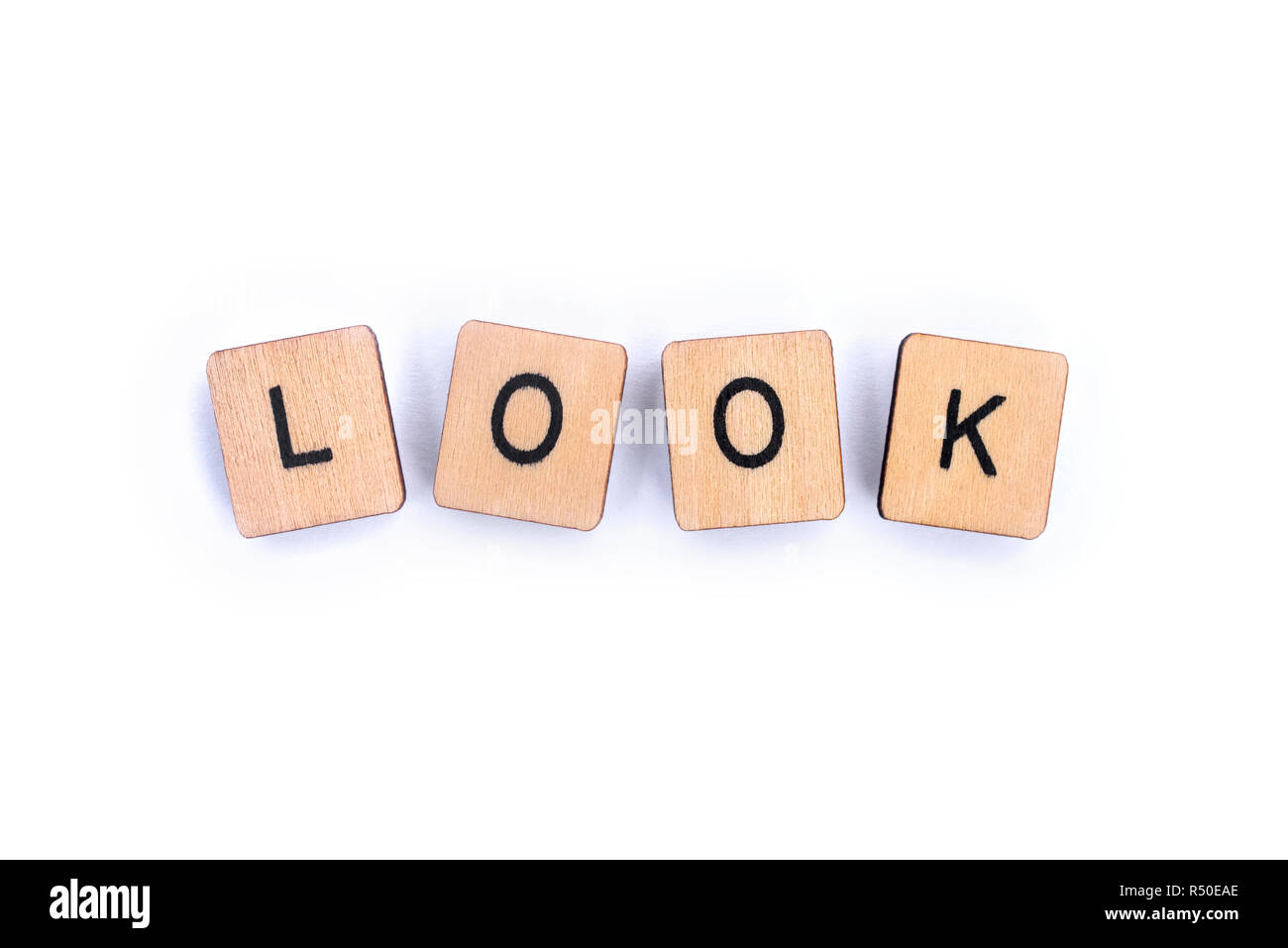 The word LOOK, spelt with wooden letter tiles over a plain white ...
