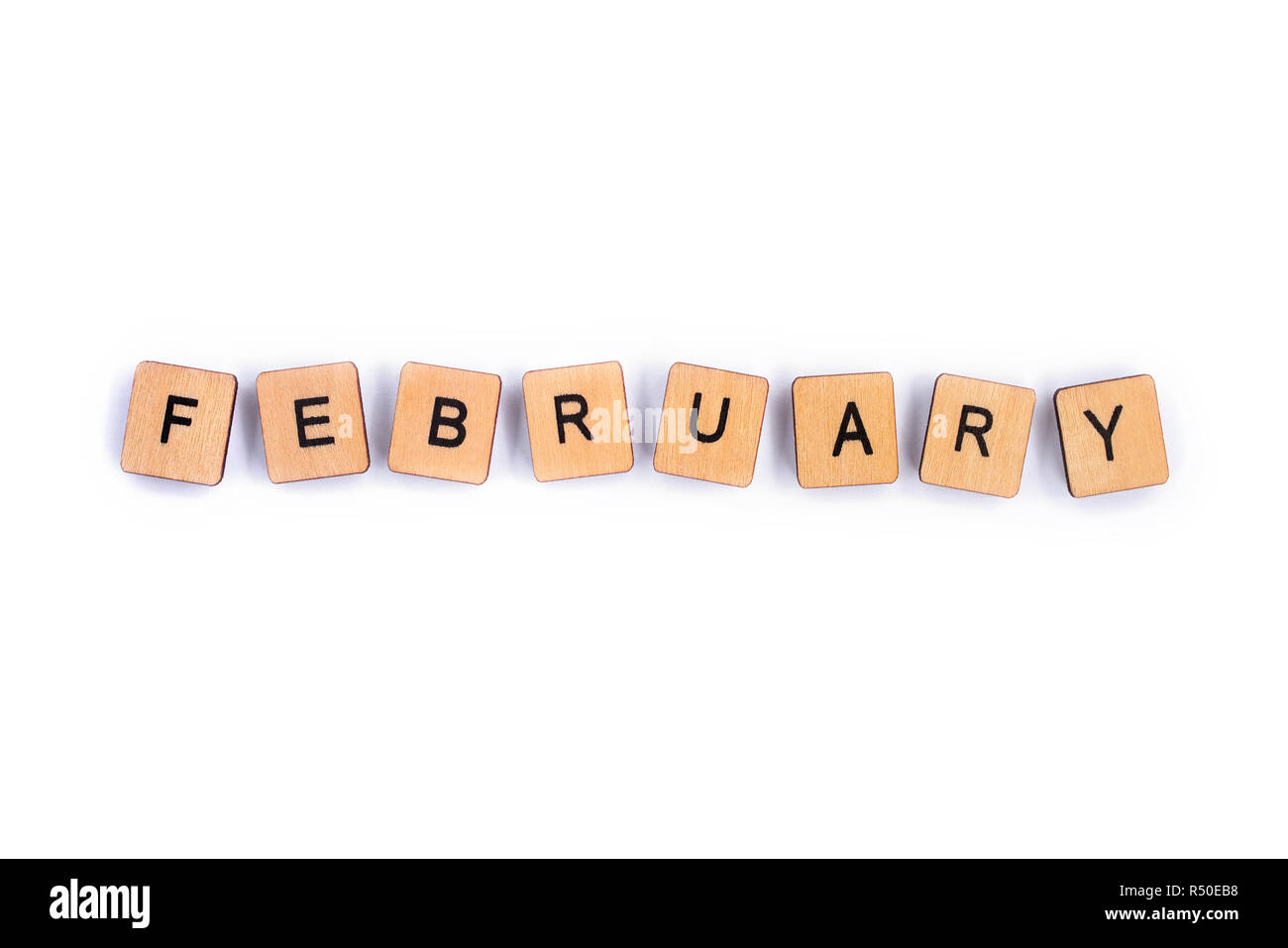 FEBRUARY, spelt with wooden letter tiles over a plain white background ...