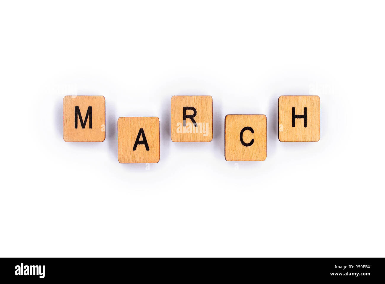 MARCH, spelt with wooden letter tiles over a plain white background ...