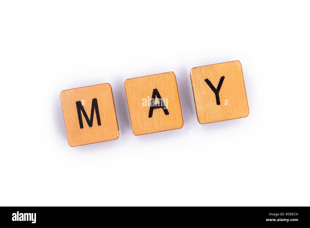 MAY, spelt with wooden letter tiles over a plain white background Stock ...