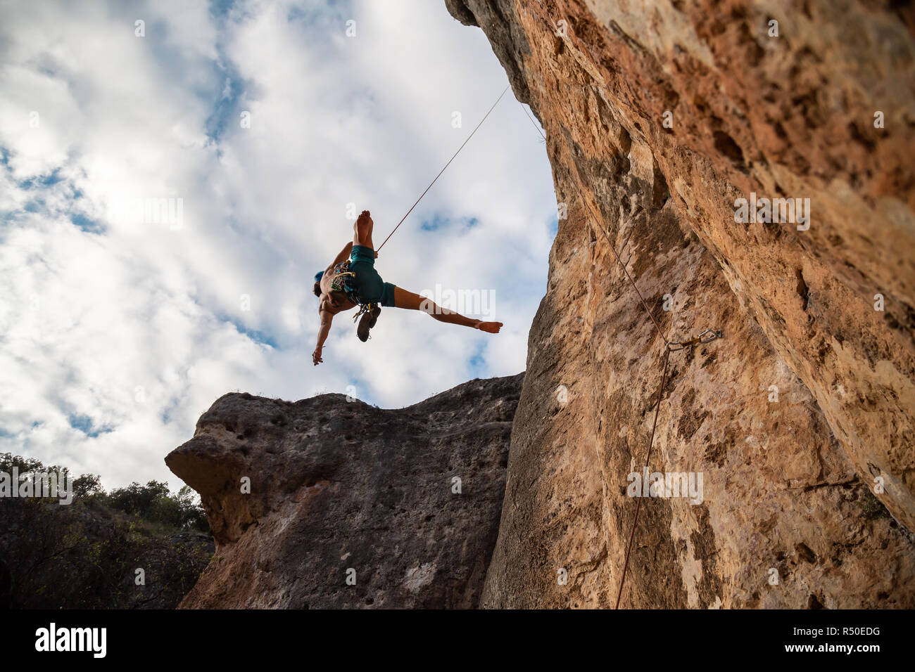 Man in hardhat hanging on rope while doing rappel and showing ...