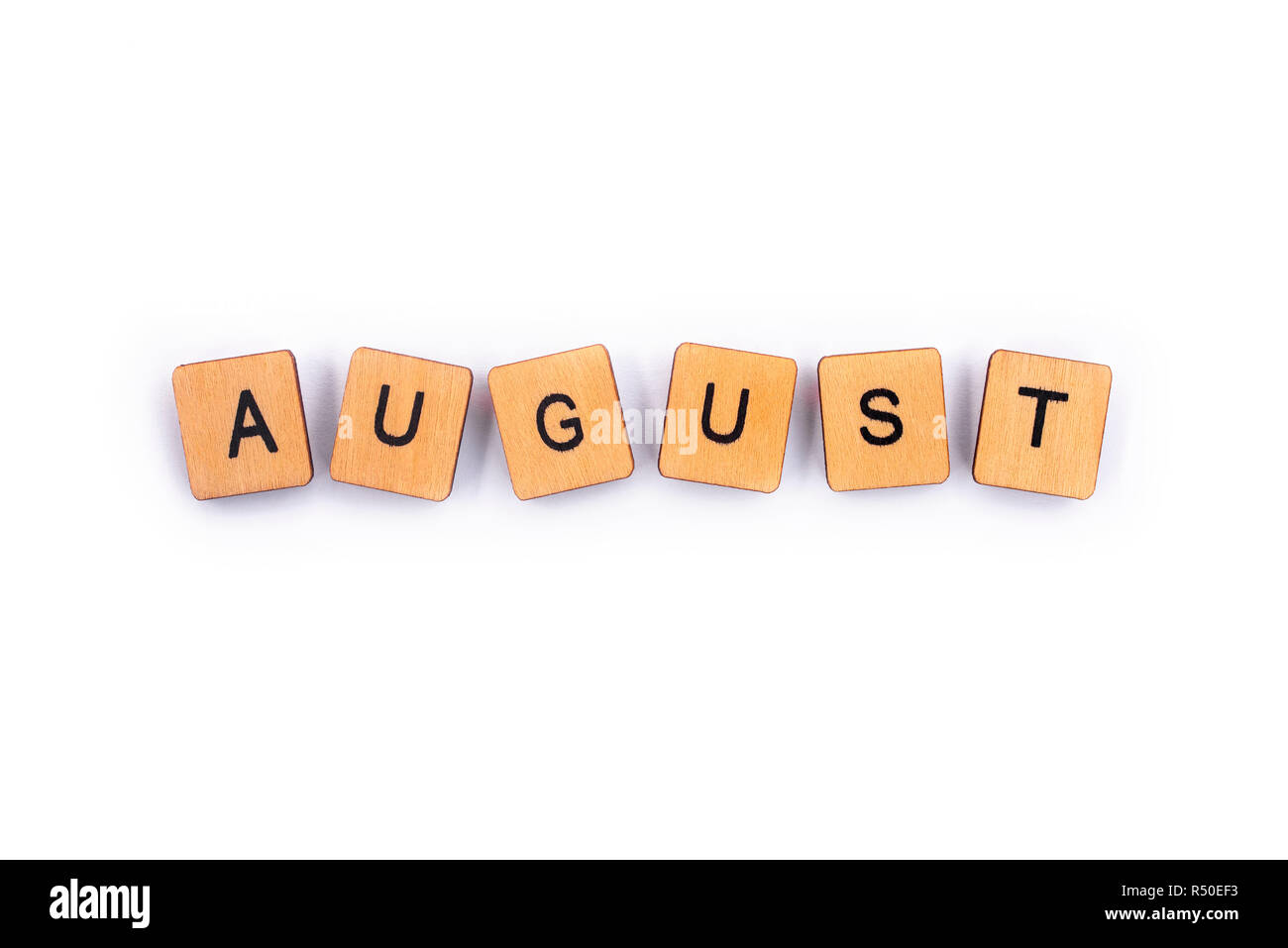 AUGUST, spelt with wooden letter tiles over a plain white background ...