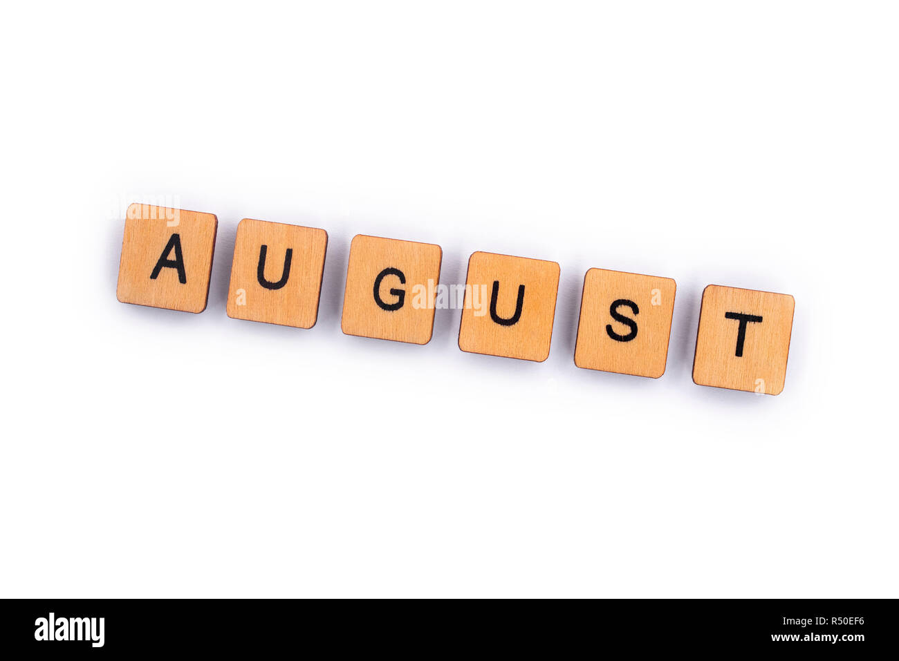 AUGUST, spelt with wooden letter tiles over a plain white background ...