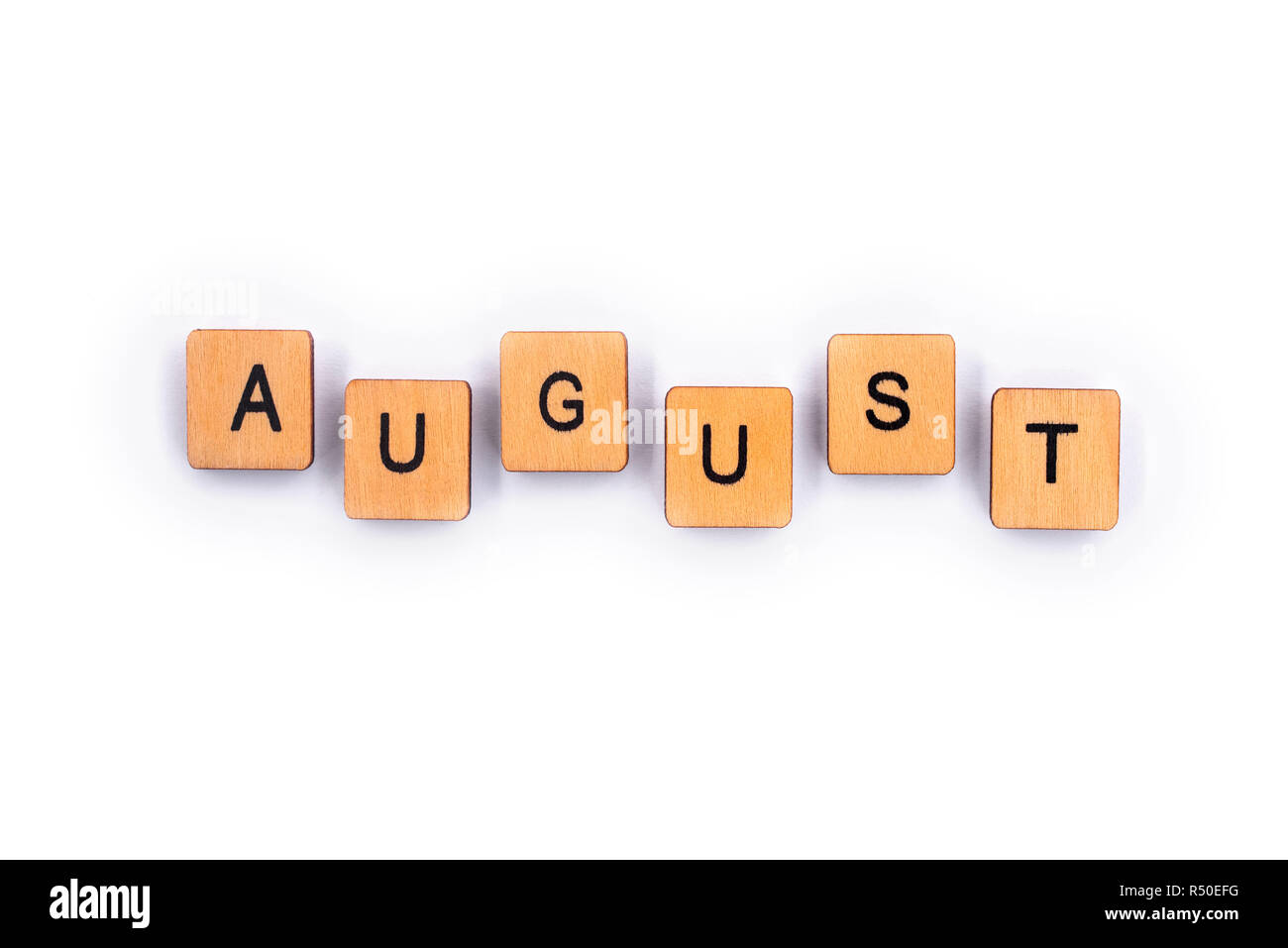 AUGUST, spelt with wooden letter tiles over a plain white background ...