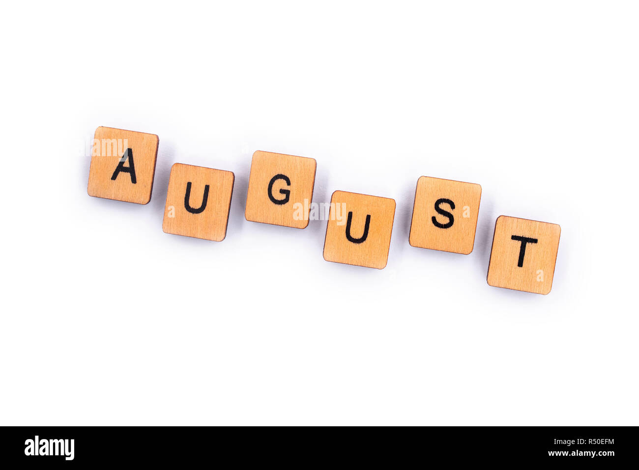 AUGUST, spelt with wooden letter tiles over a plain white background ...