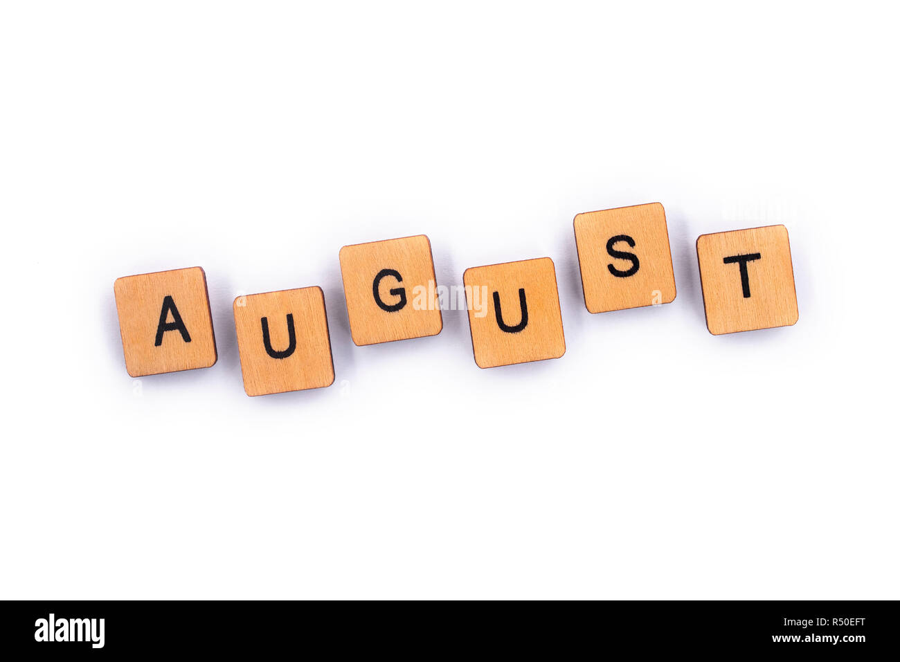 AUGUST, spelt with wooden letter tiles over a plain white background ...