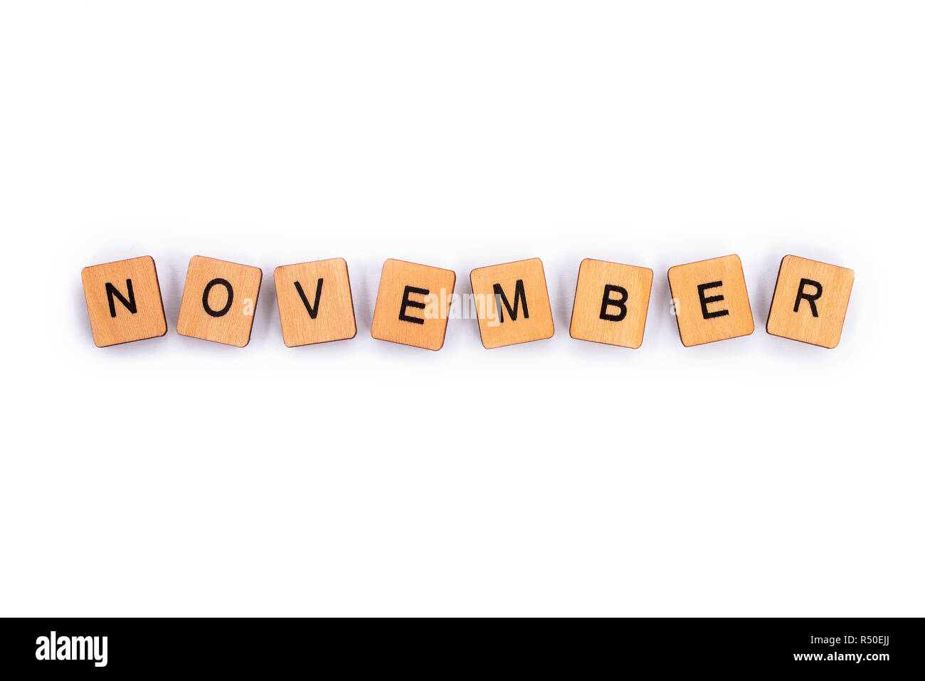 NOVEMBER, spelt with wooden letter tiles over a plain white background ...