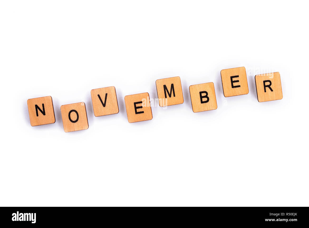 NOVEMBER, spelt with wooden letter tiles over a plain white background ...