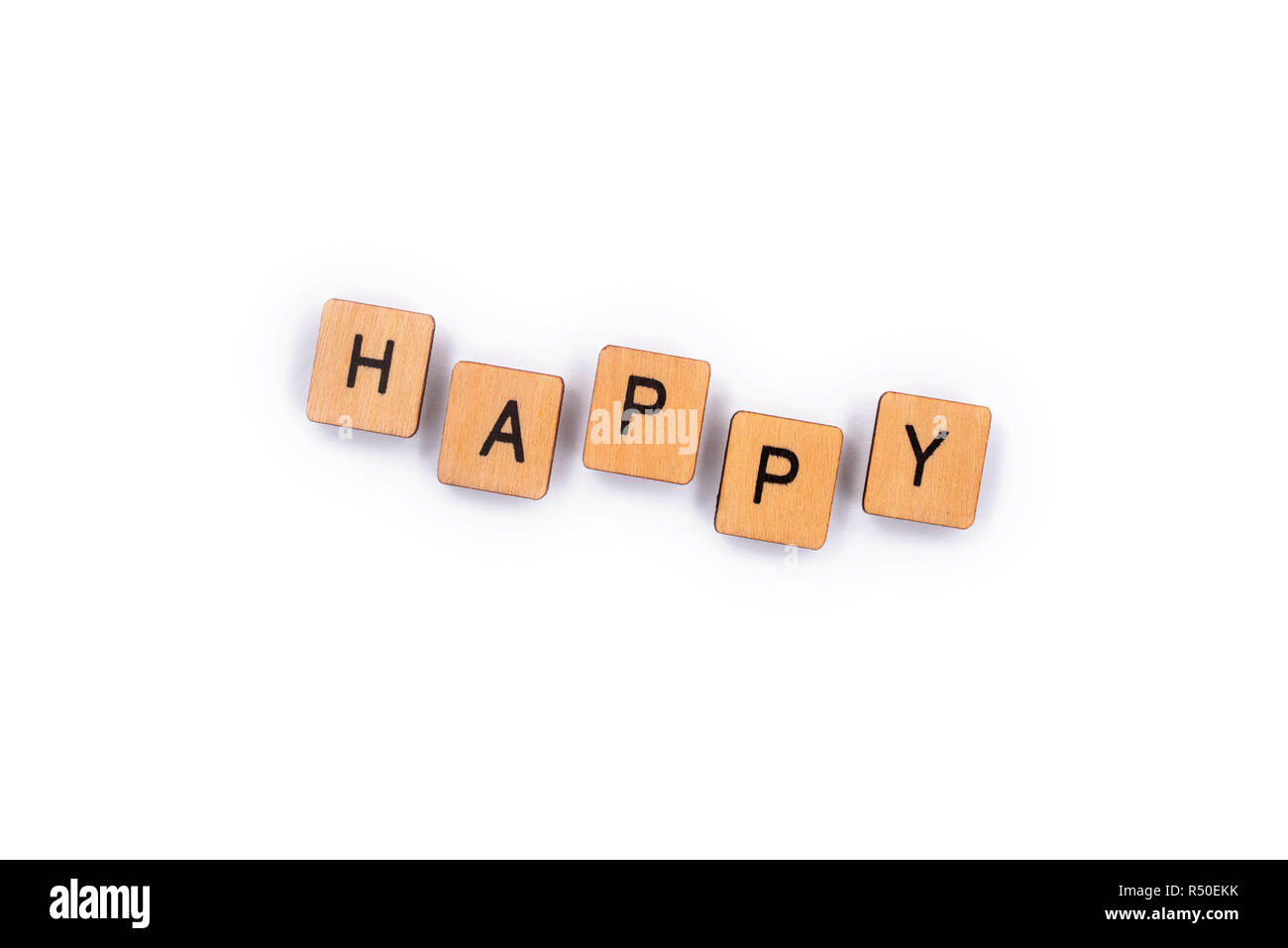 HAPPY, spelt with wooden letter tiles over a plain white background ...