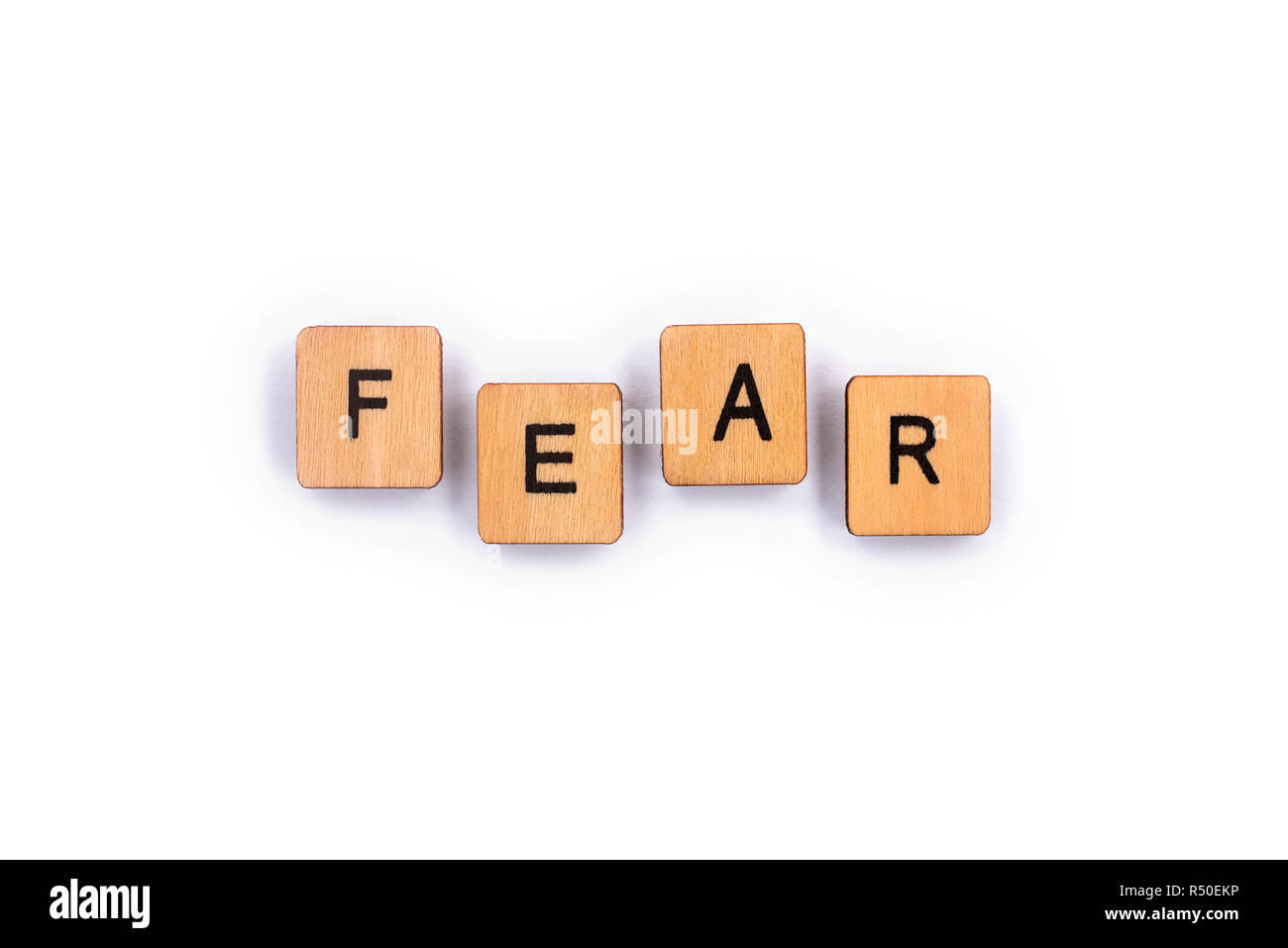 FEAR, spelt with wooden letter tiles over a plain white background ...