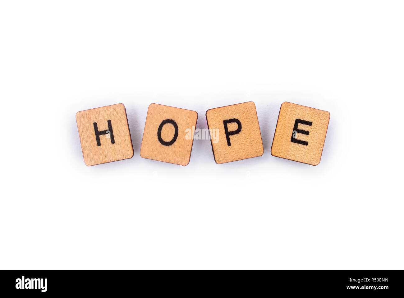 The word HOPE, spelt with wooden letter tiles over a plain white ...
