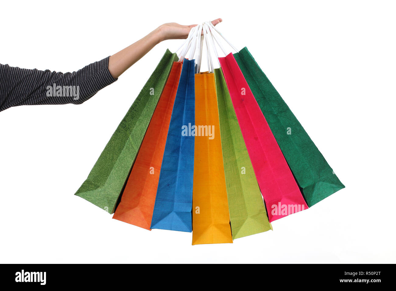 Female hand holding colorful shopping bags against white Stock Photo ...