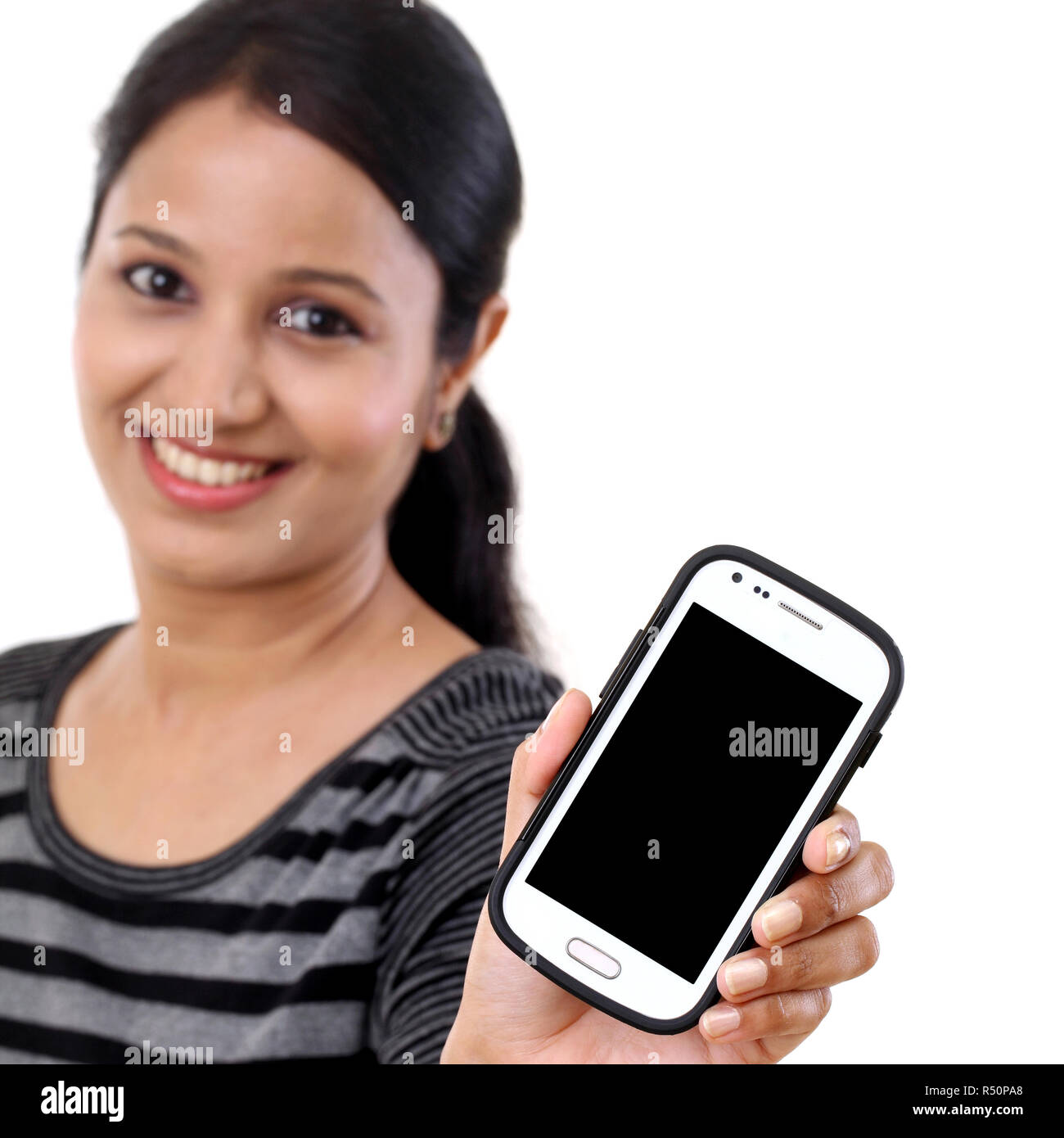Young woman holding mobile phone against white background Stock Photo ...