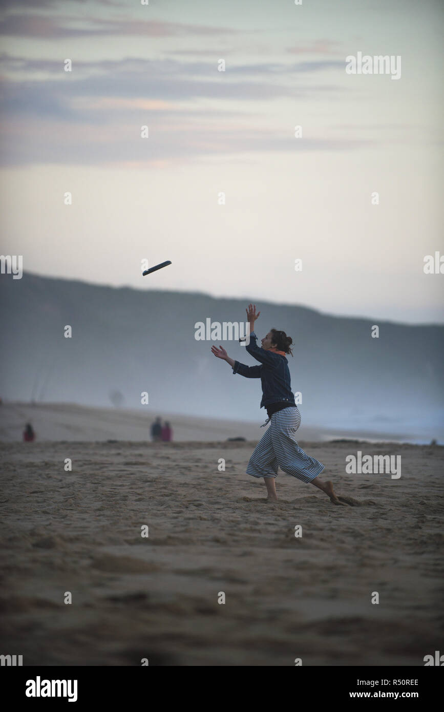Woman playing frisbee on the beach Stock Photo - Alamy