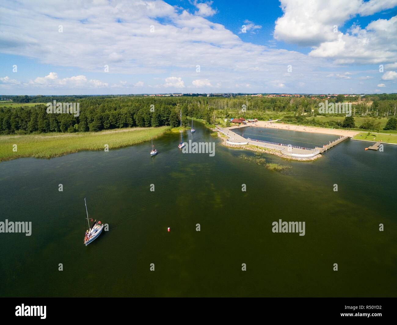 Aerial view of yachts sailing on Mamry Lake, concrete quay and town ...