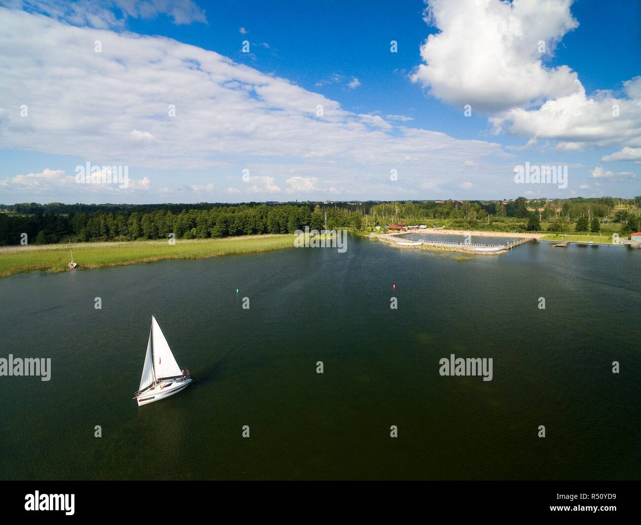 Aerial view of yachts sailing on Mamry Lake, concrete quay and town ...