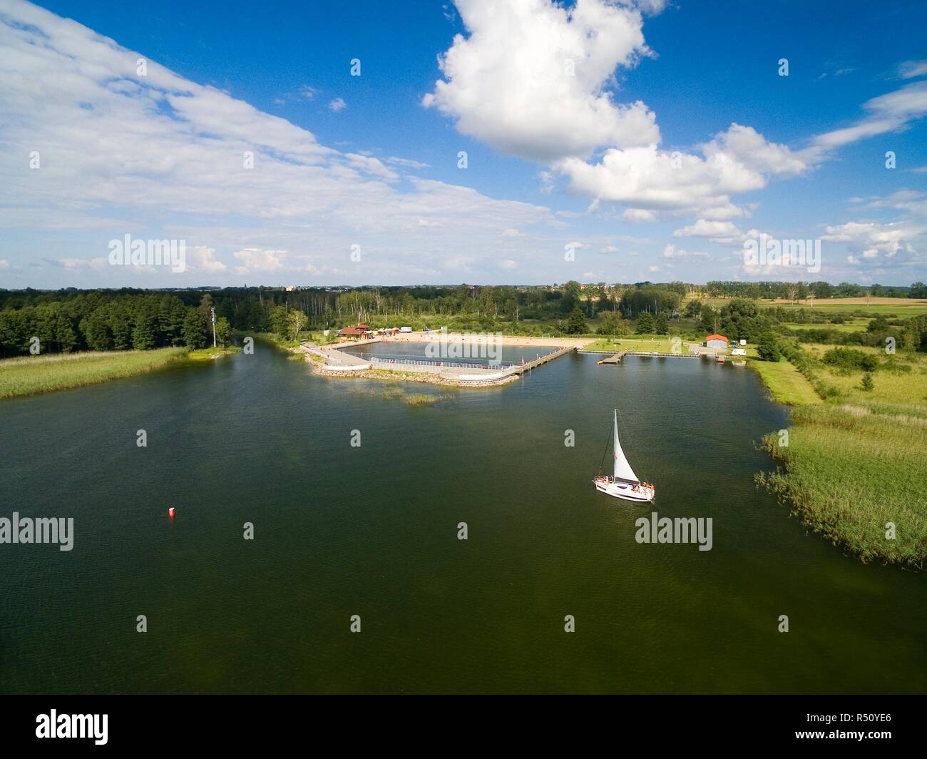 Aerial view of yachts sailing on Mamry Lake, concrete quay and town ...