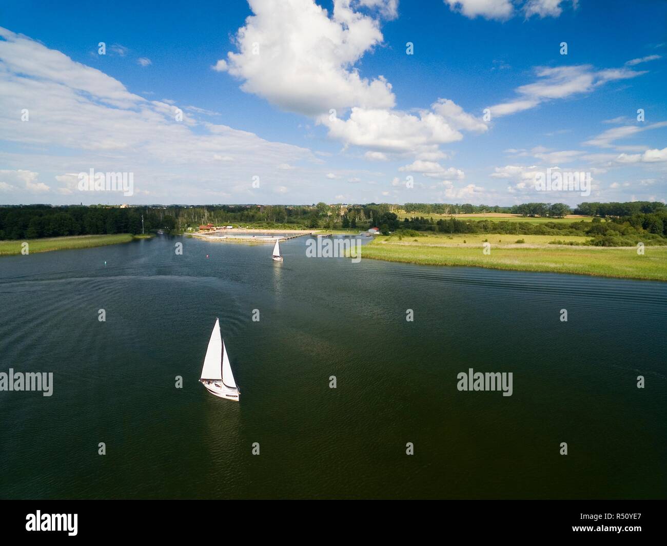 Aerial view of yachts sailing on Mamry Lake, concrete quay and town ...