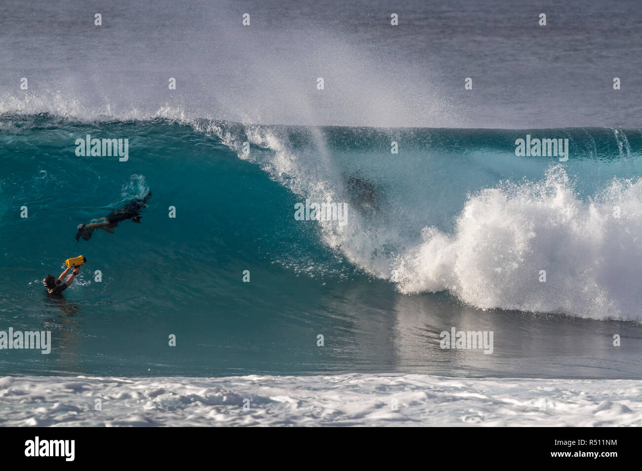 Surf photographers shooting a surfer in a wave Stock Photo - Alamy