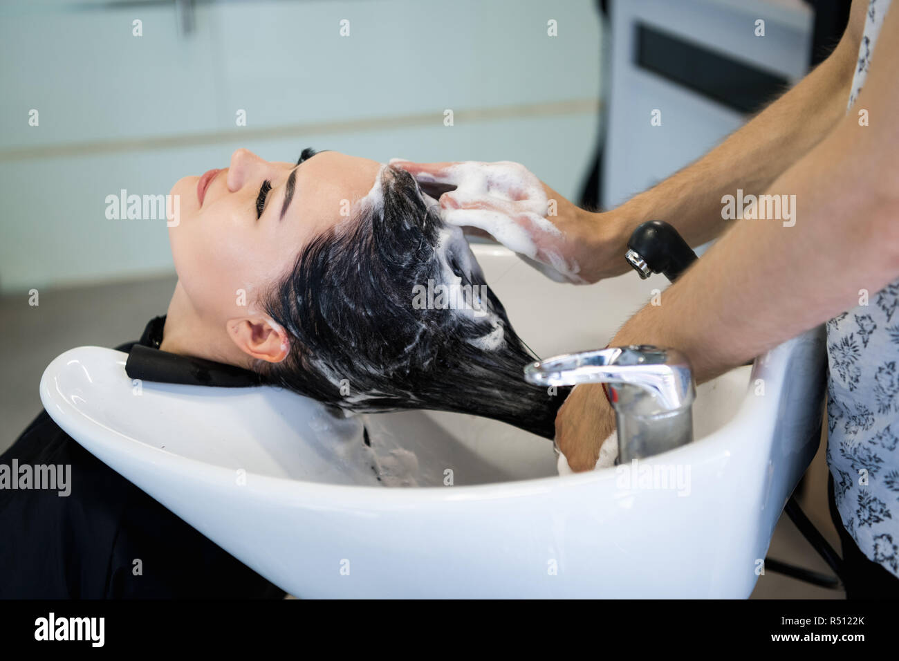 Beauty and people concept - happy young woman with hairdresser washing ...