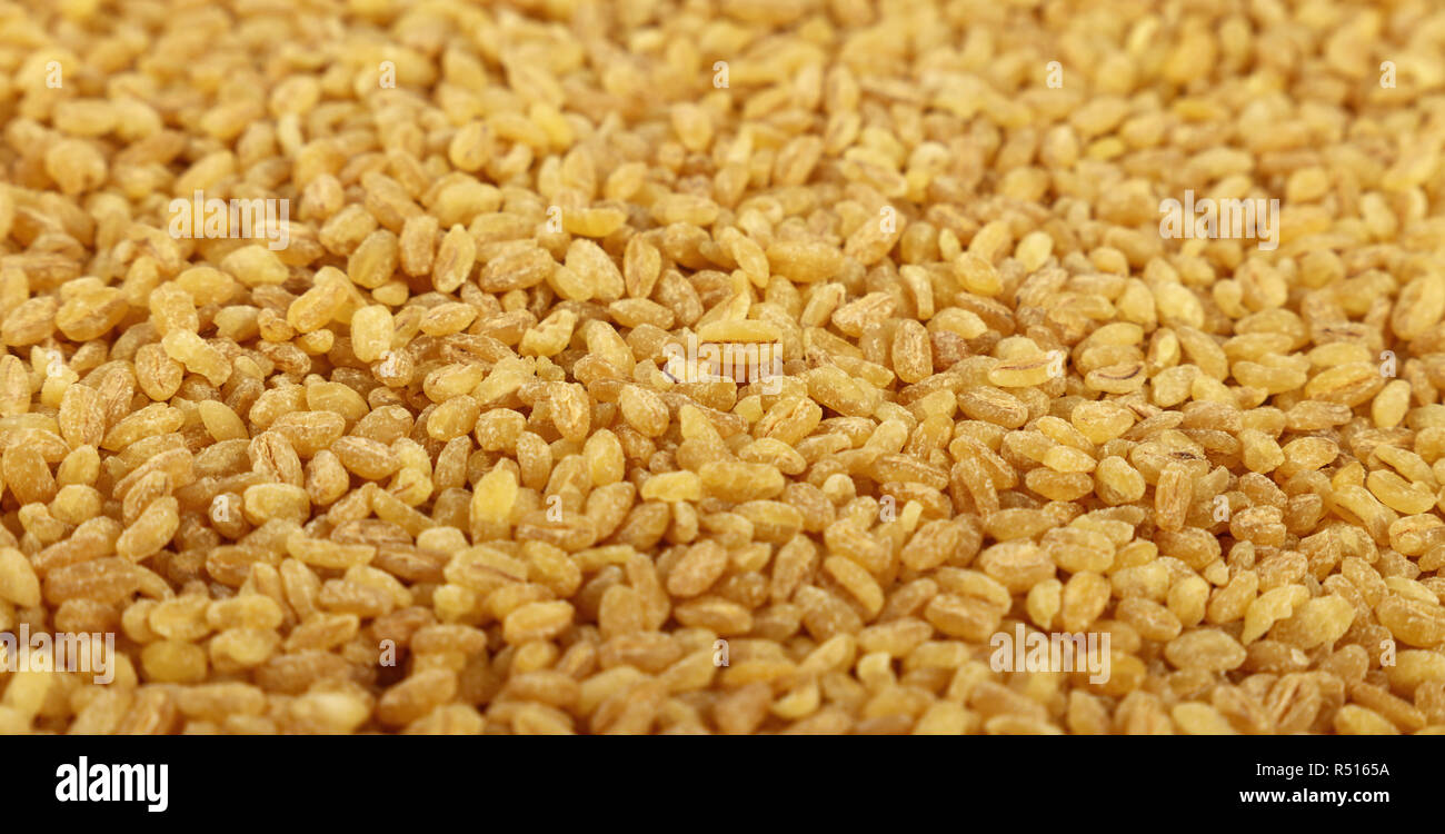 Yellow bulgur big grains close up background Stock Photo - Alamy