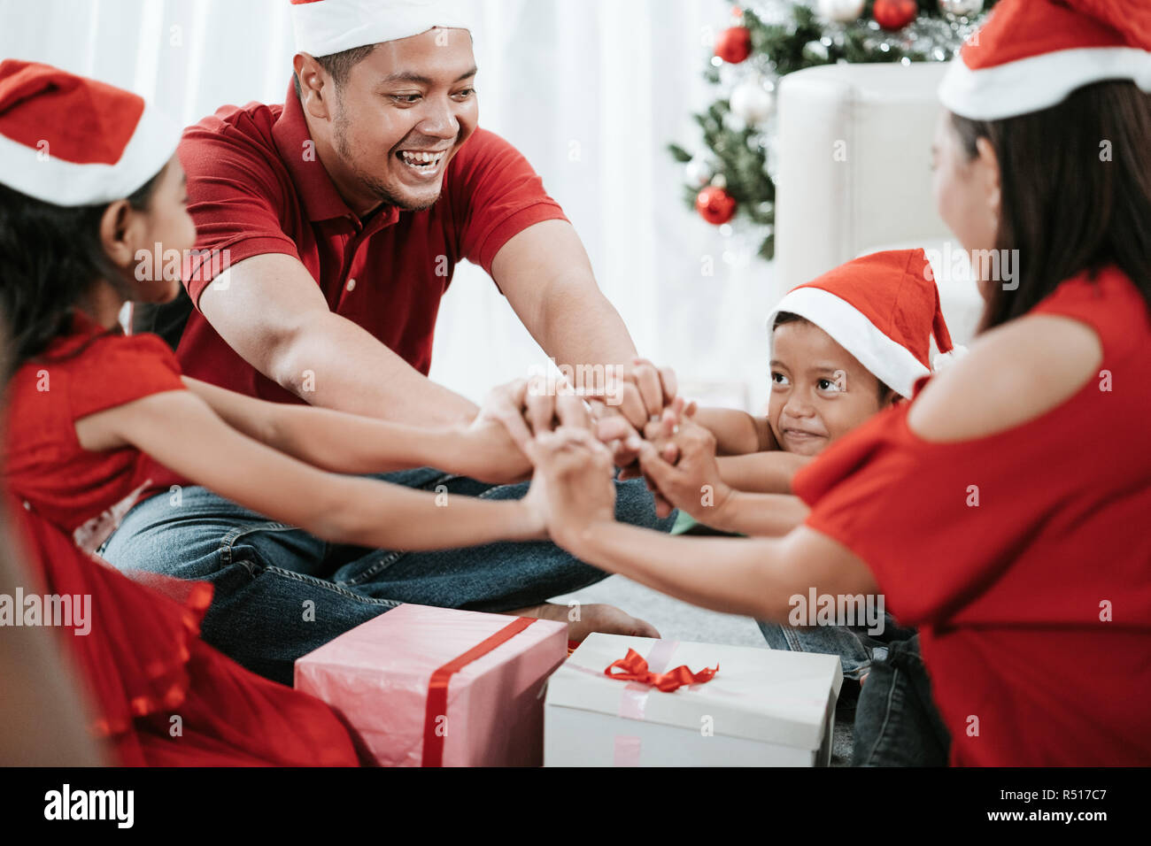 asian family put their hands together during christmas. pray and have ...