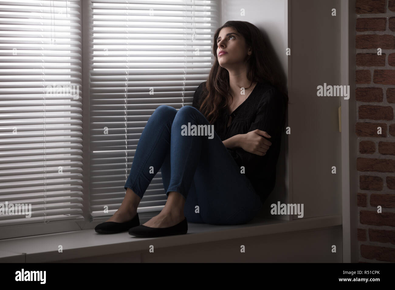 Pensive Woman Sitting By The Window Stock Photo - Alamy