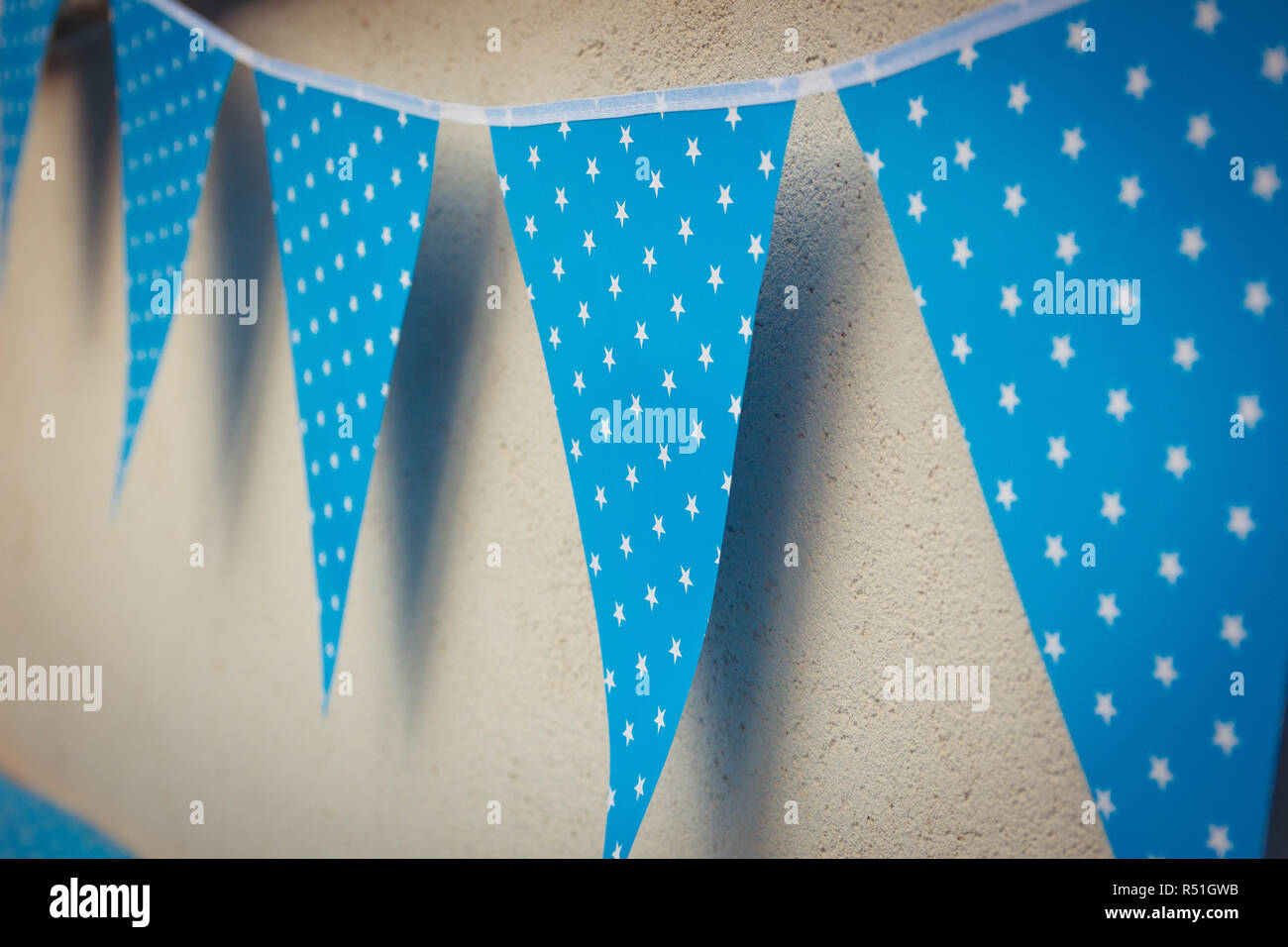 line of colorful blue party decorations flags with white stars ...