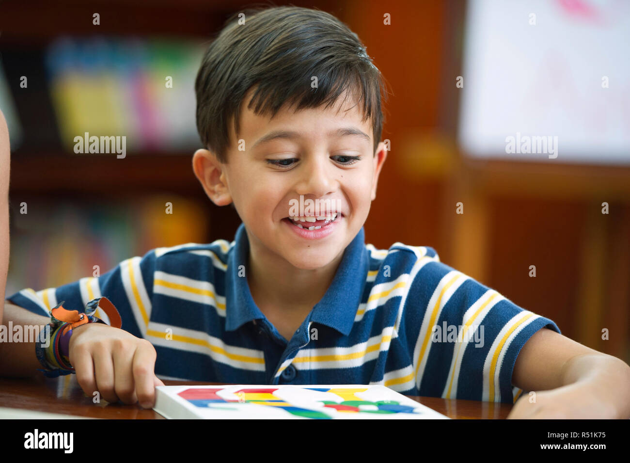Hispanic boy reading book laughing hi-res stock photography and images ...