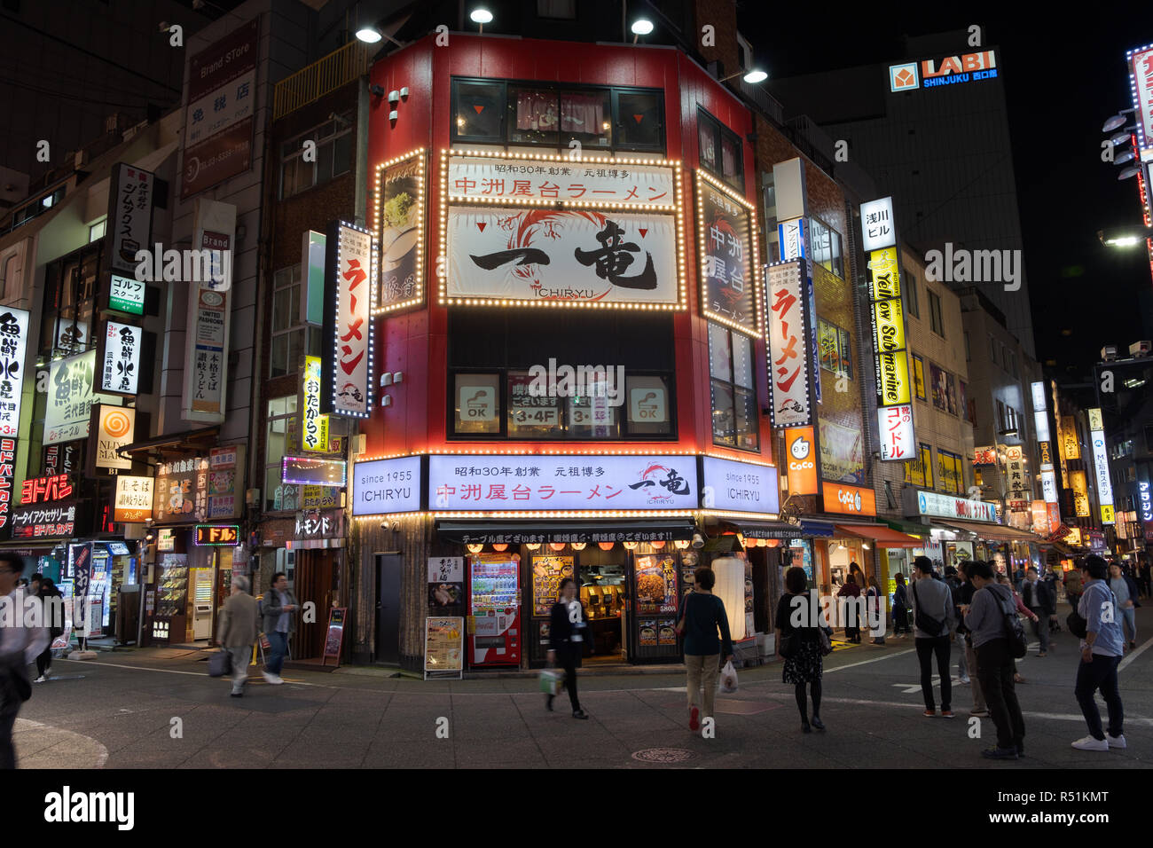 Main street in Shinjuku, Tokyo, Japan at night with pedestrians walking ...